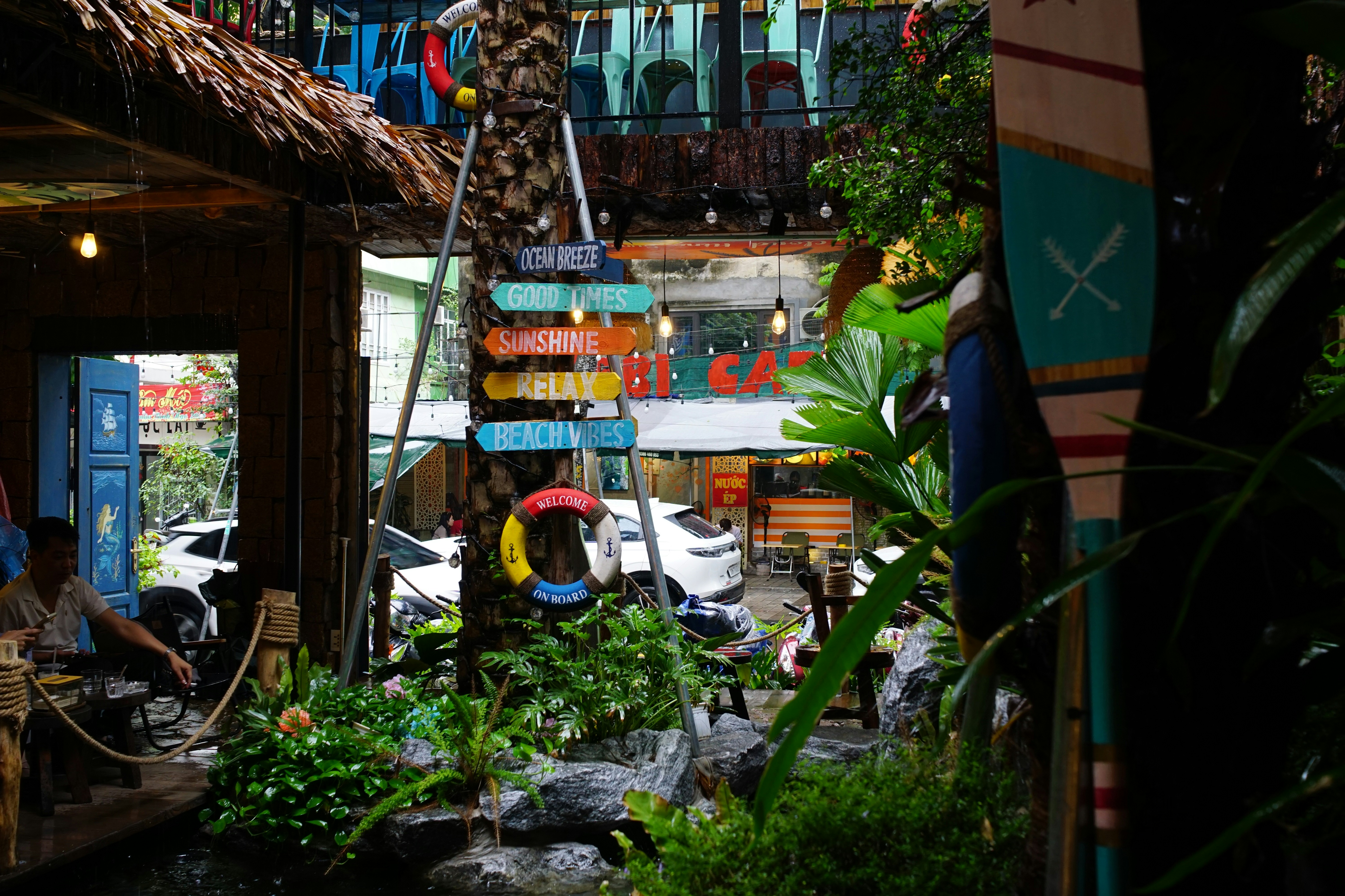 Tropical Courtyard Café Signage Amid Lush Greenery and Striking Oceanic Hues