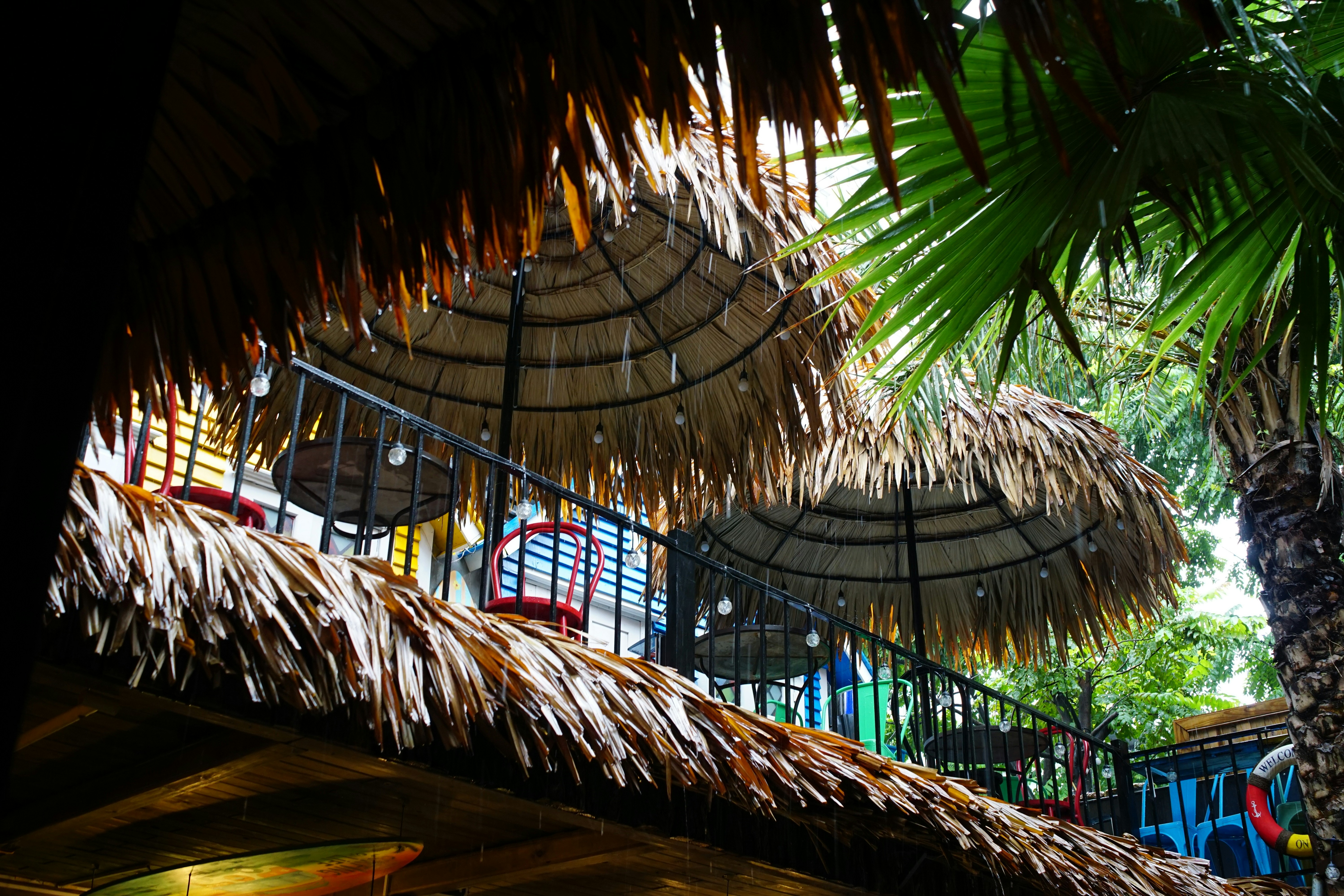 Thatched Overhangs and Louvered Balcony: A Tropical Café Canopy