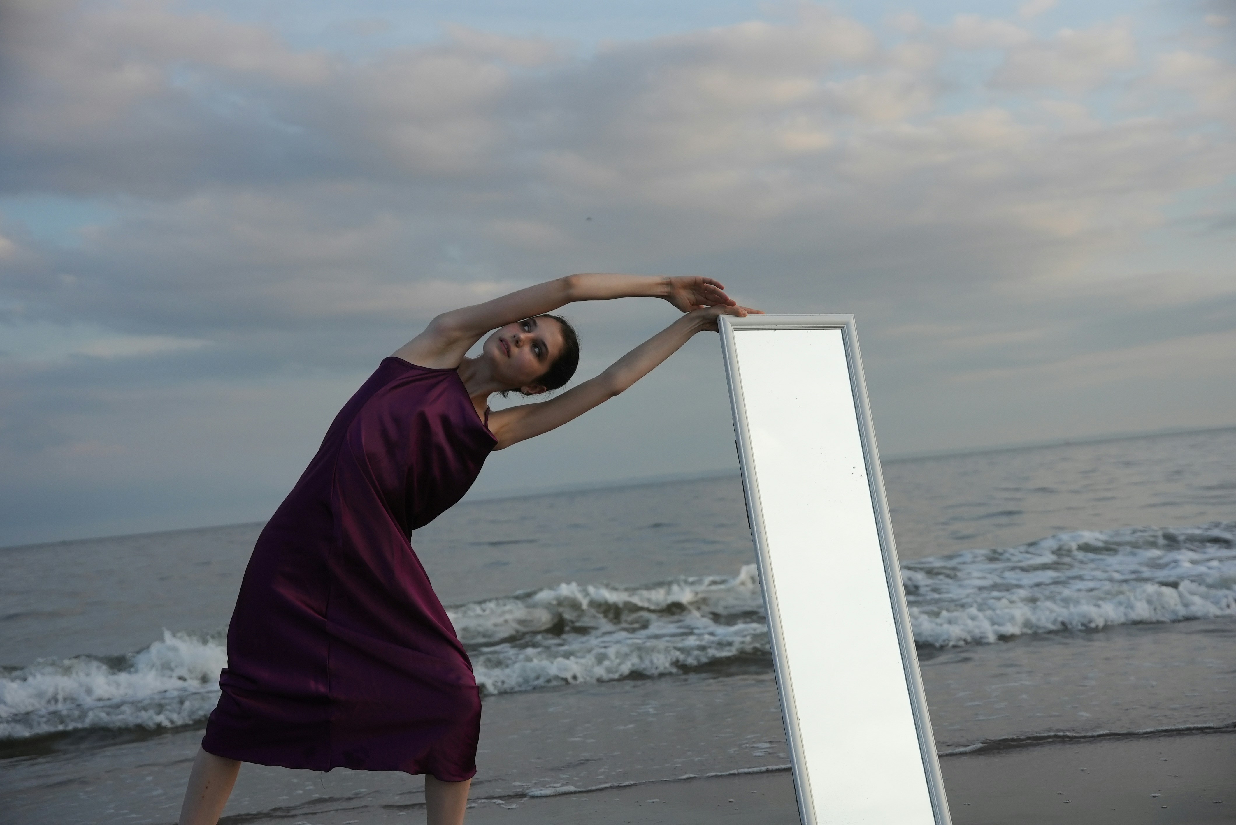 Tilted Portrait by the Sea: A Flowing Pose with a Standing Mirror