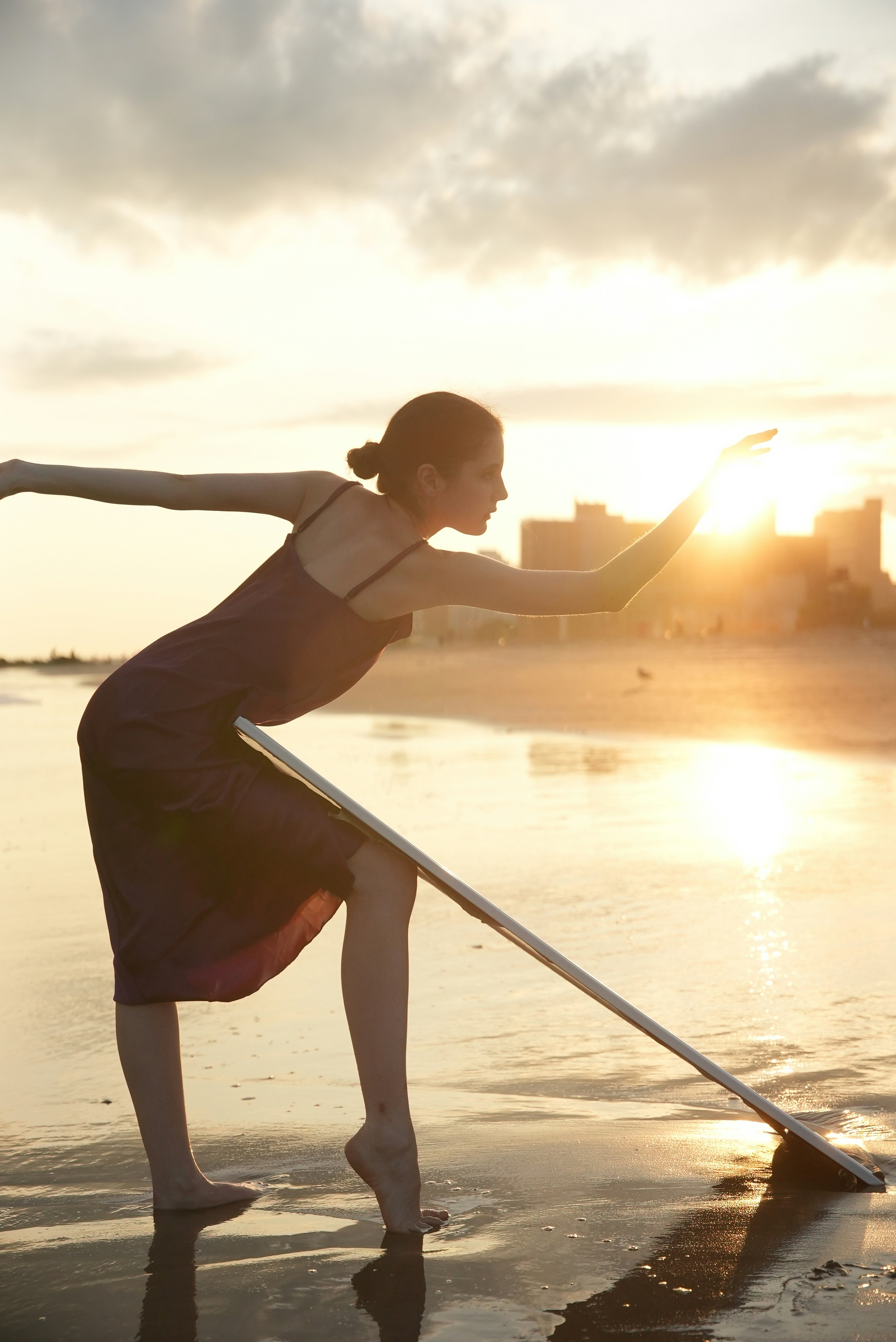Grace in the Sunset Edge: A Surfer's Silhouette on Wet Sand