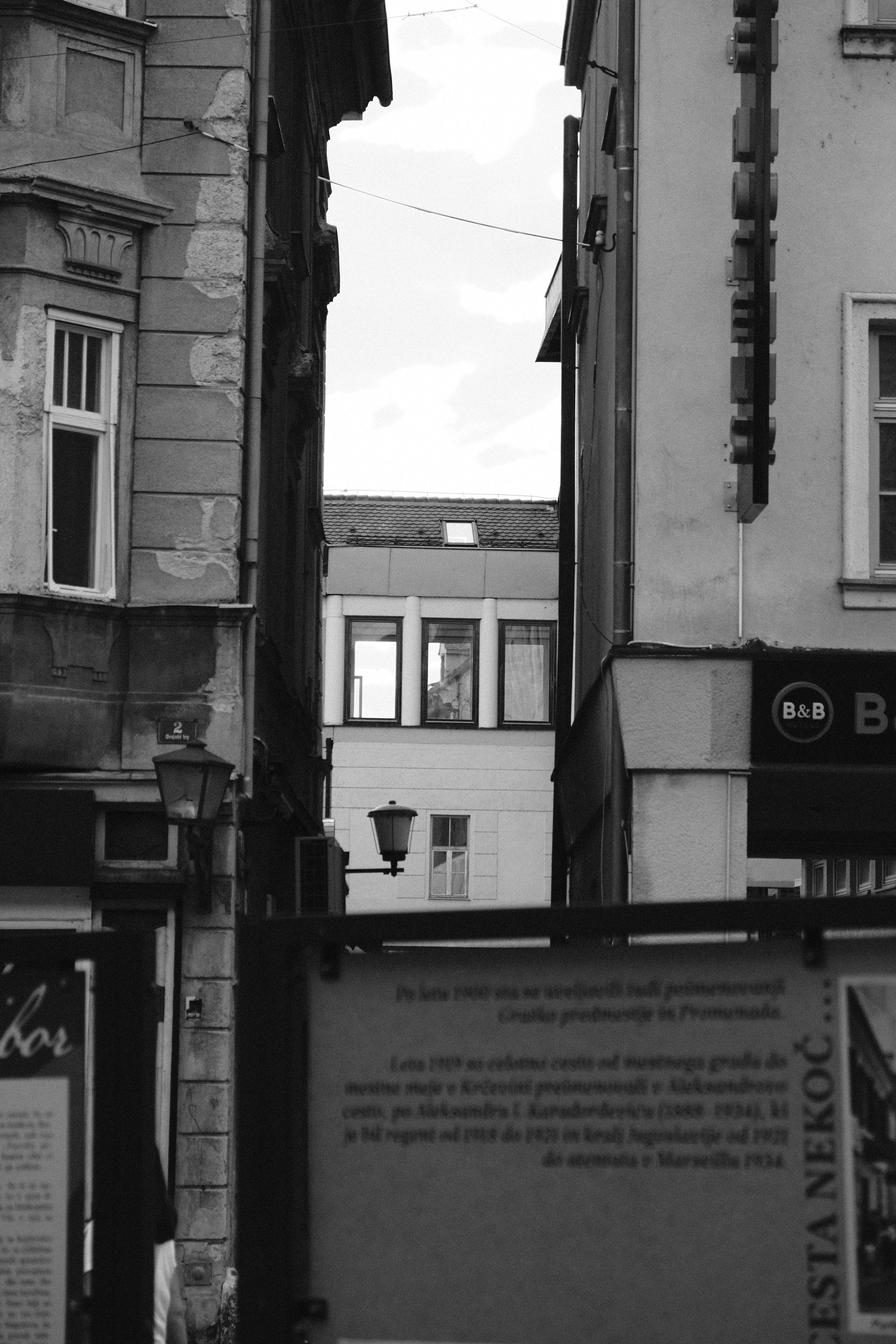 A narrow alleyway between two old buildings with a modern building in the distance