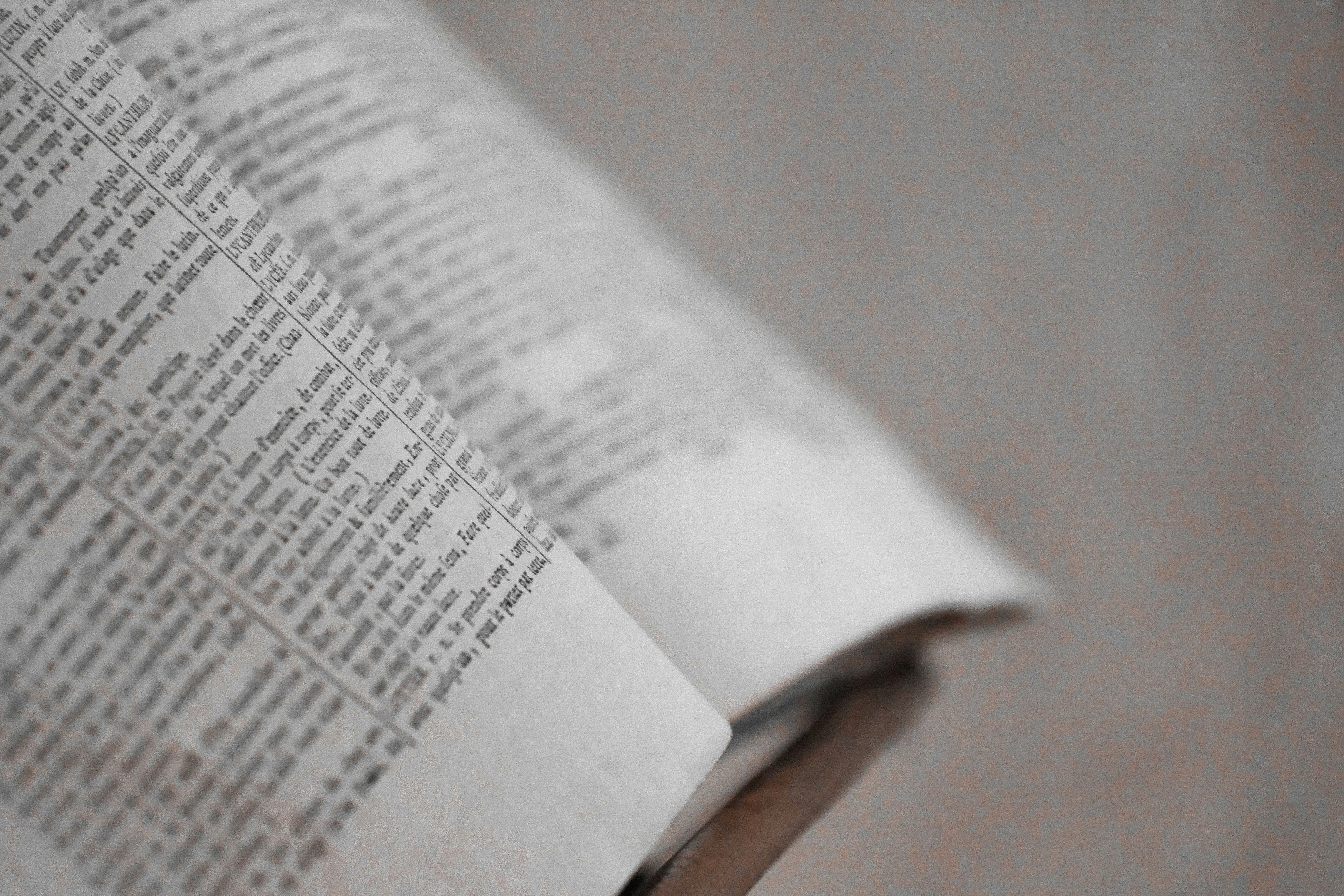 Close-up of a folded newspaper resting in a wooden holder with a shallow depth of field and muted tones.