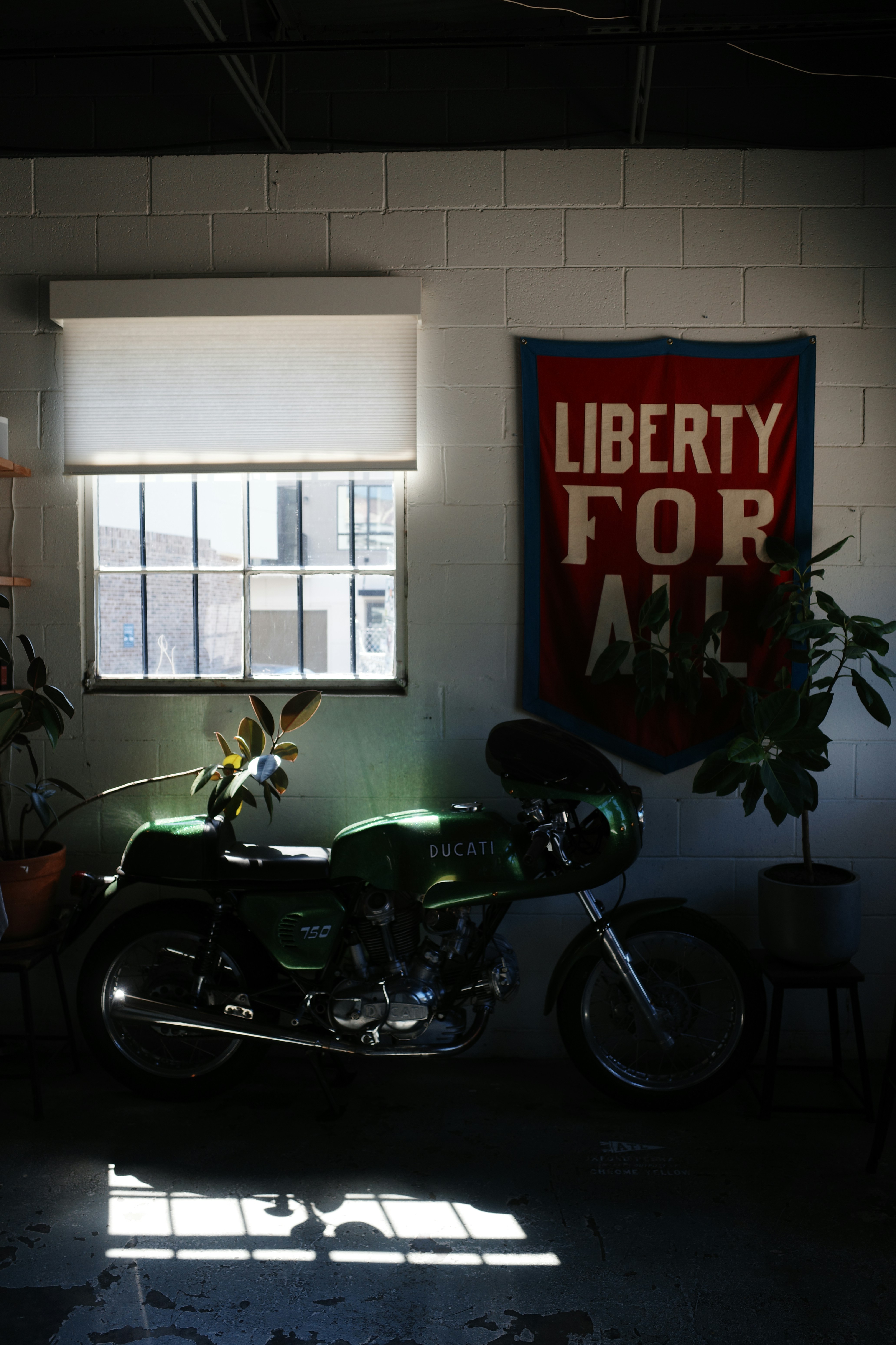 Green Ducati and Liberty Banner: A Quiet Garage Portrait
