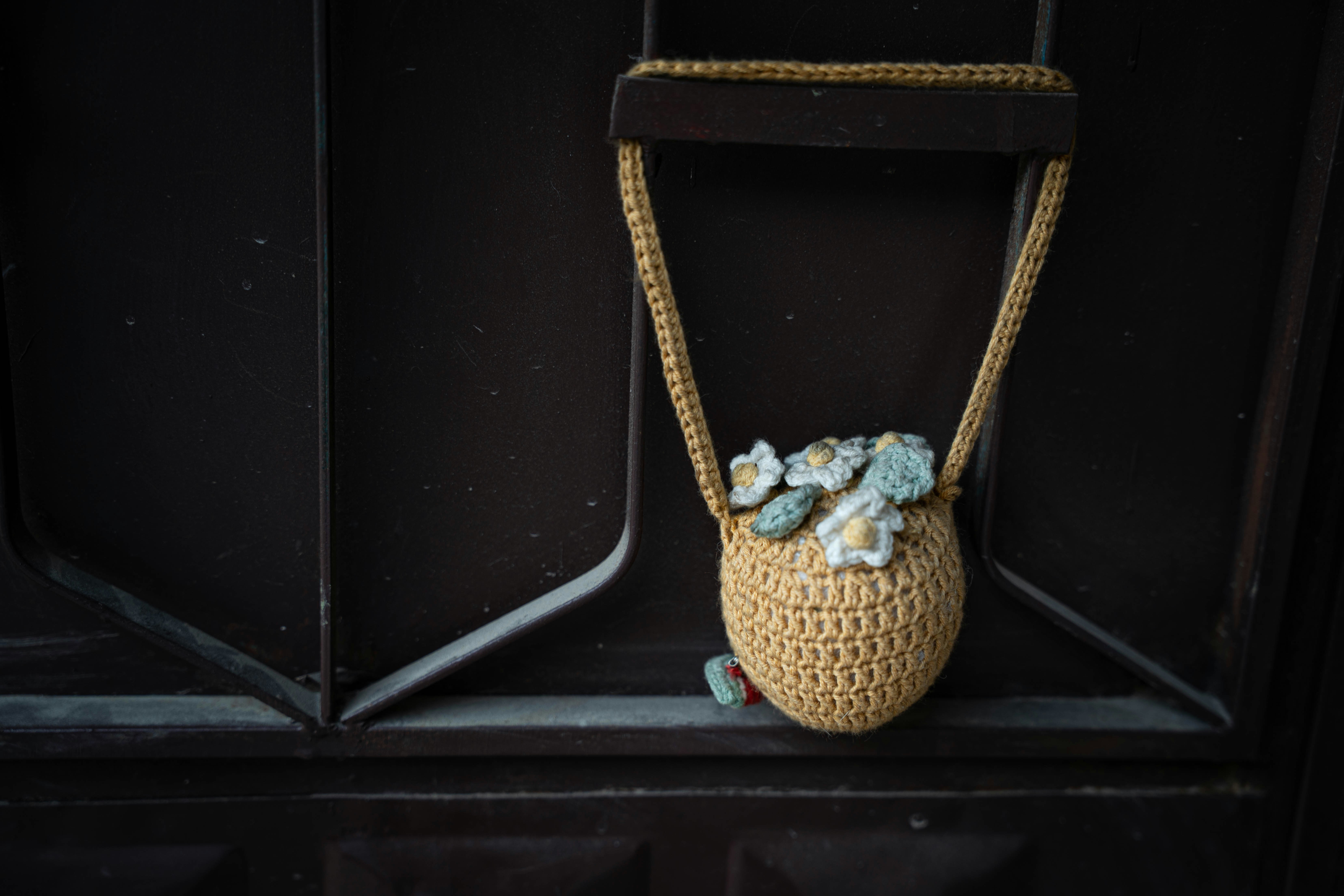 Weaved Bloom: A Tiny Basket Pendant Adorns a Dark Doorway