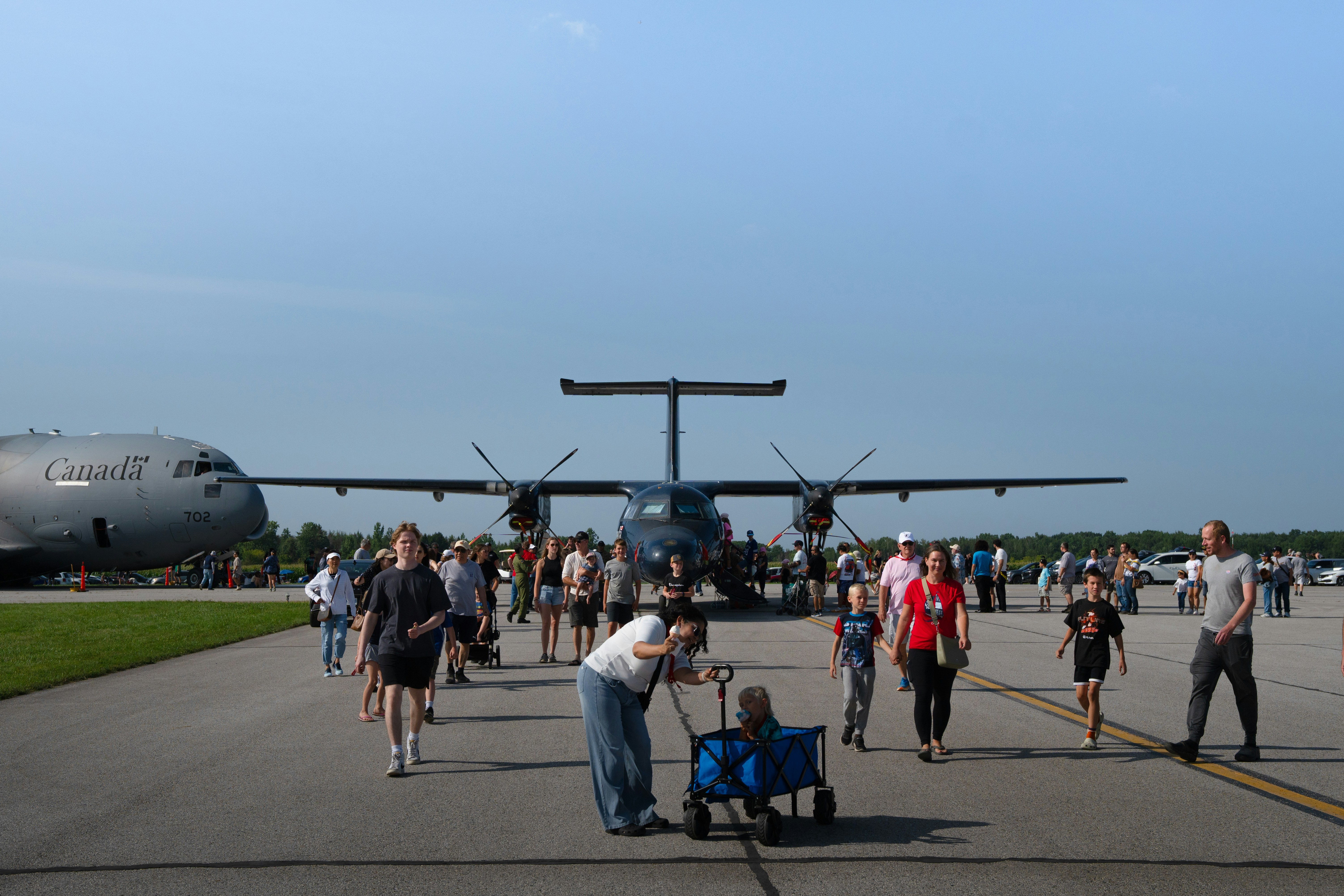Crowd at a Midfield Tarmac Rally Around Twin Engine Aircrafts