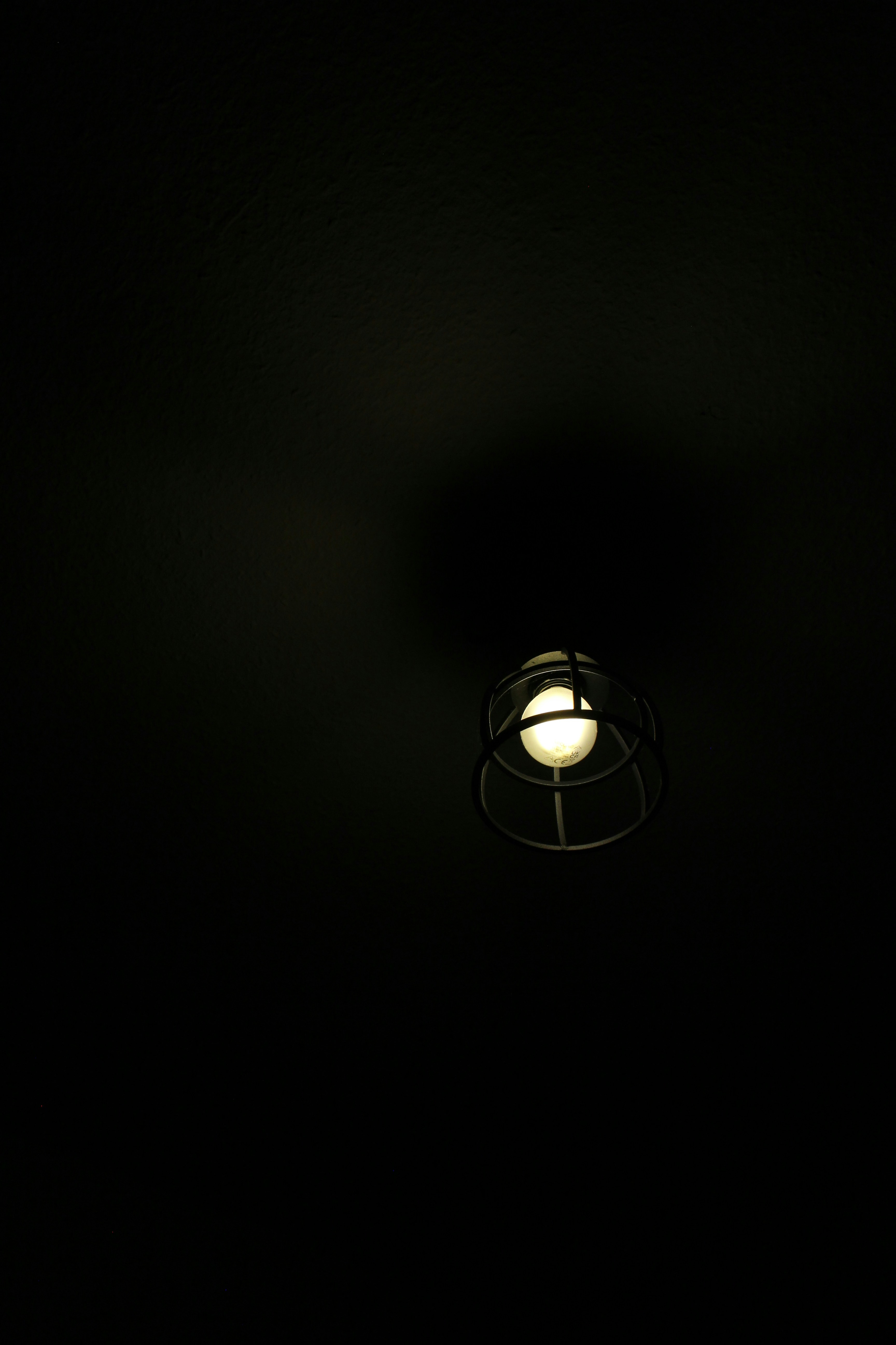 Haloed Glow: A Single Fixture in a Velvet Darkness