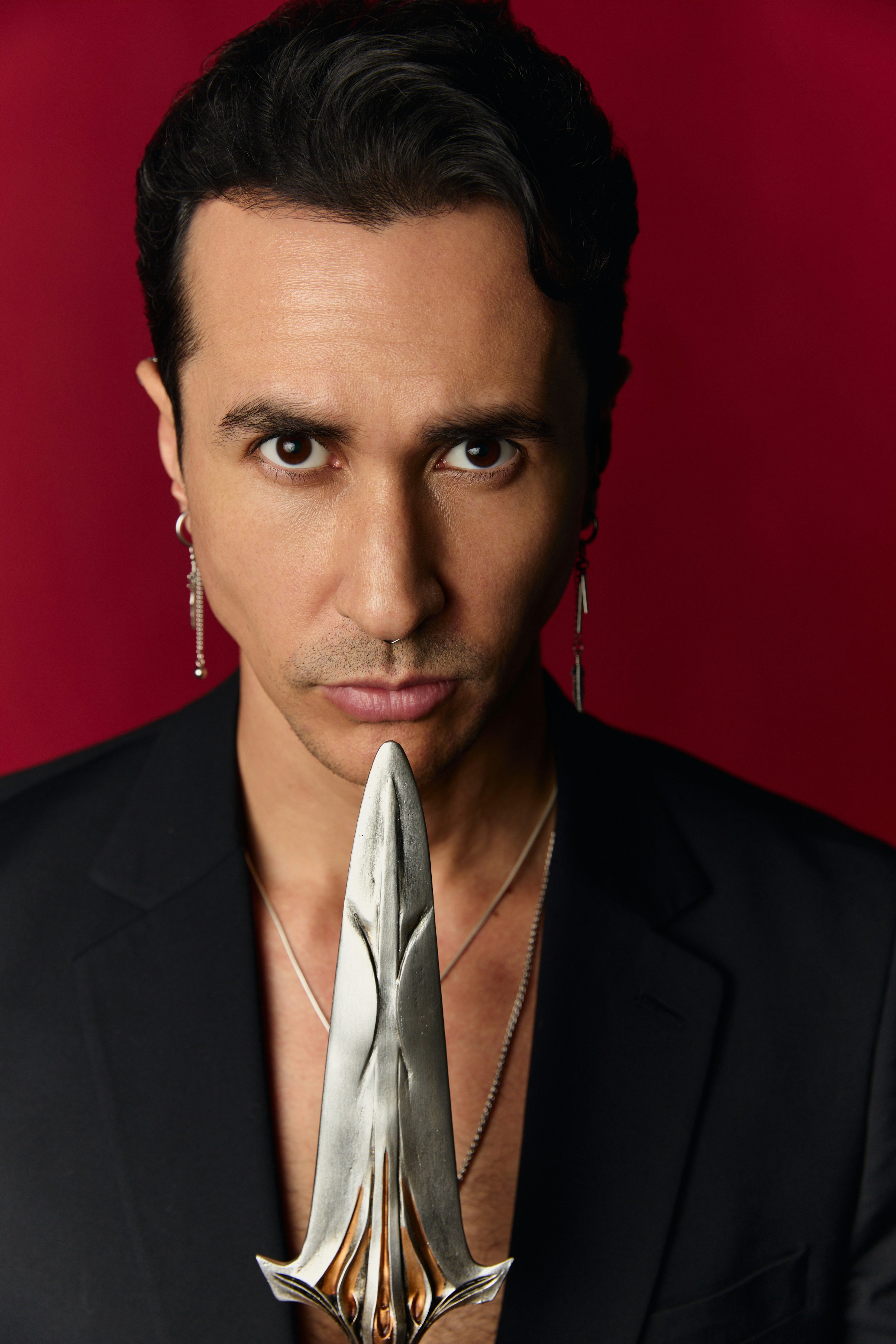 Crimson Backdrop, Sharp Gaze: A Portrait with a Metallic Scepter