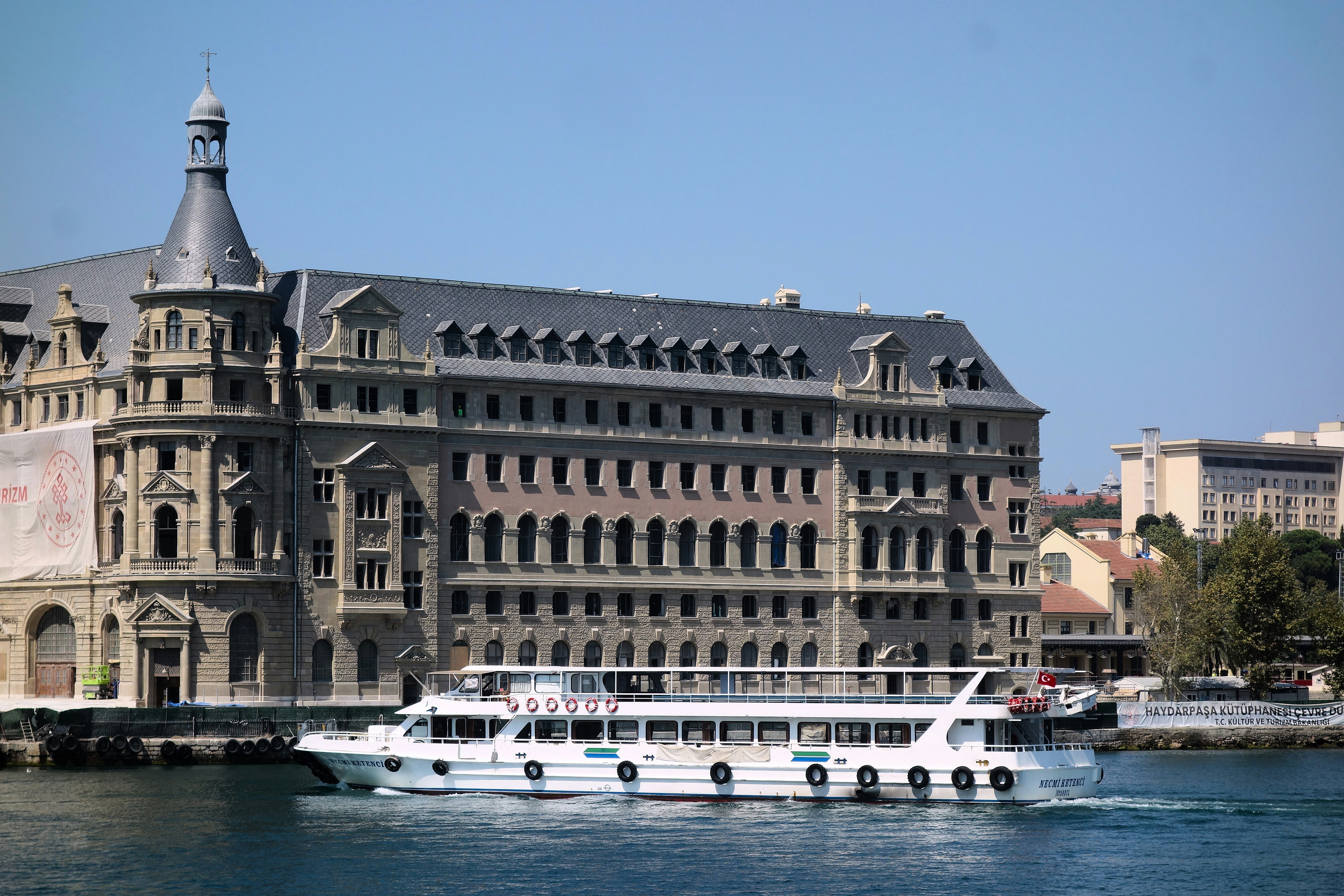 Harborfront Beacon: A Historic Edifice Overlooked by a Passenger Boat