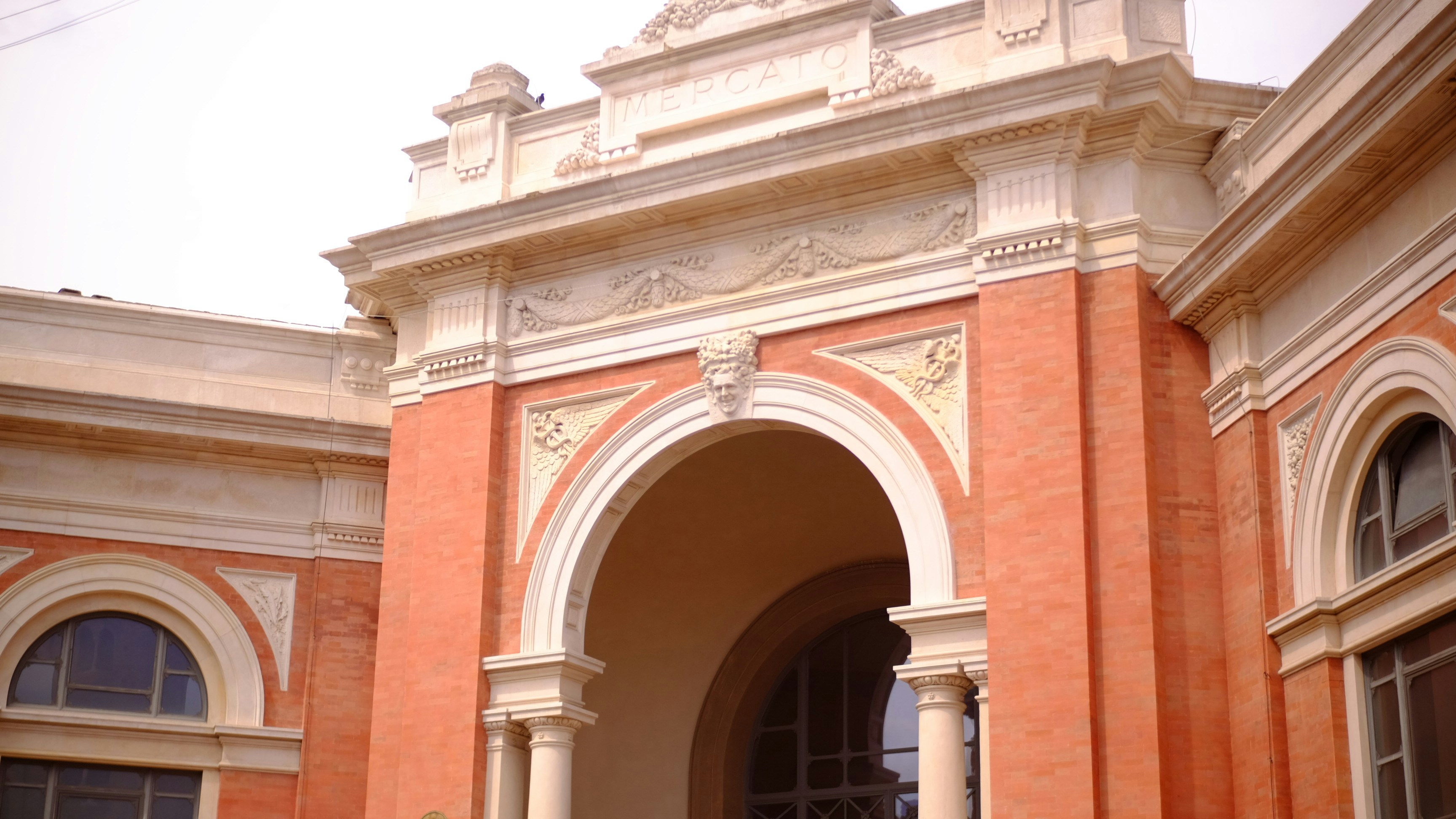 Archway Central: Sunlit Facade of a Historic Studded Arch