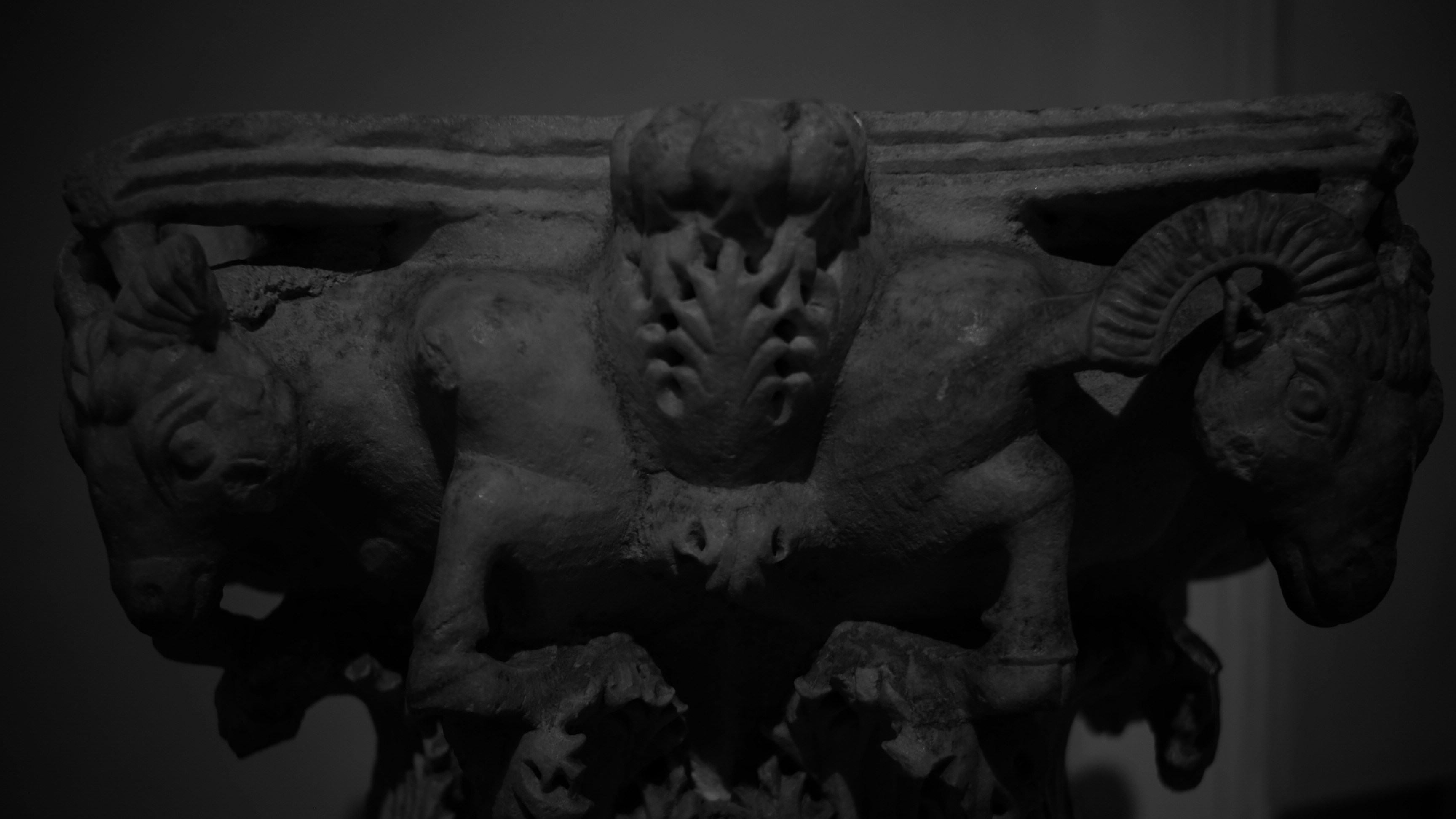 Shadowed Carved Guardian: A Low-Lit Stone Relief in Focus