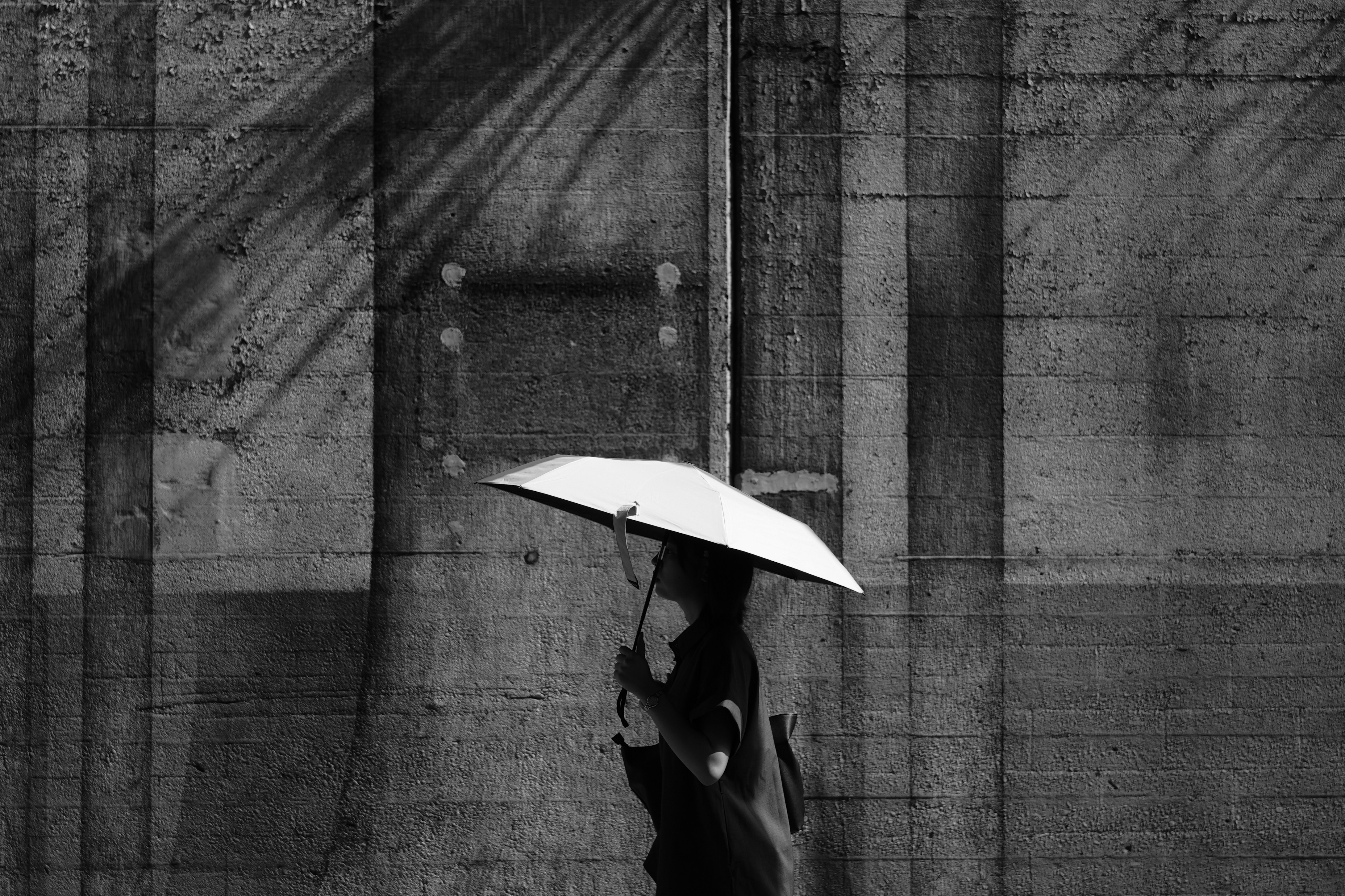 Umbrella Across a Quiet Facade