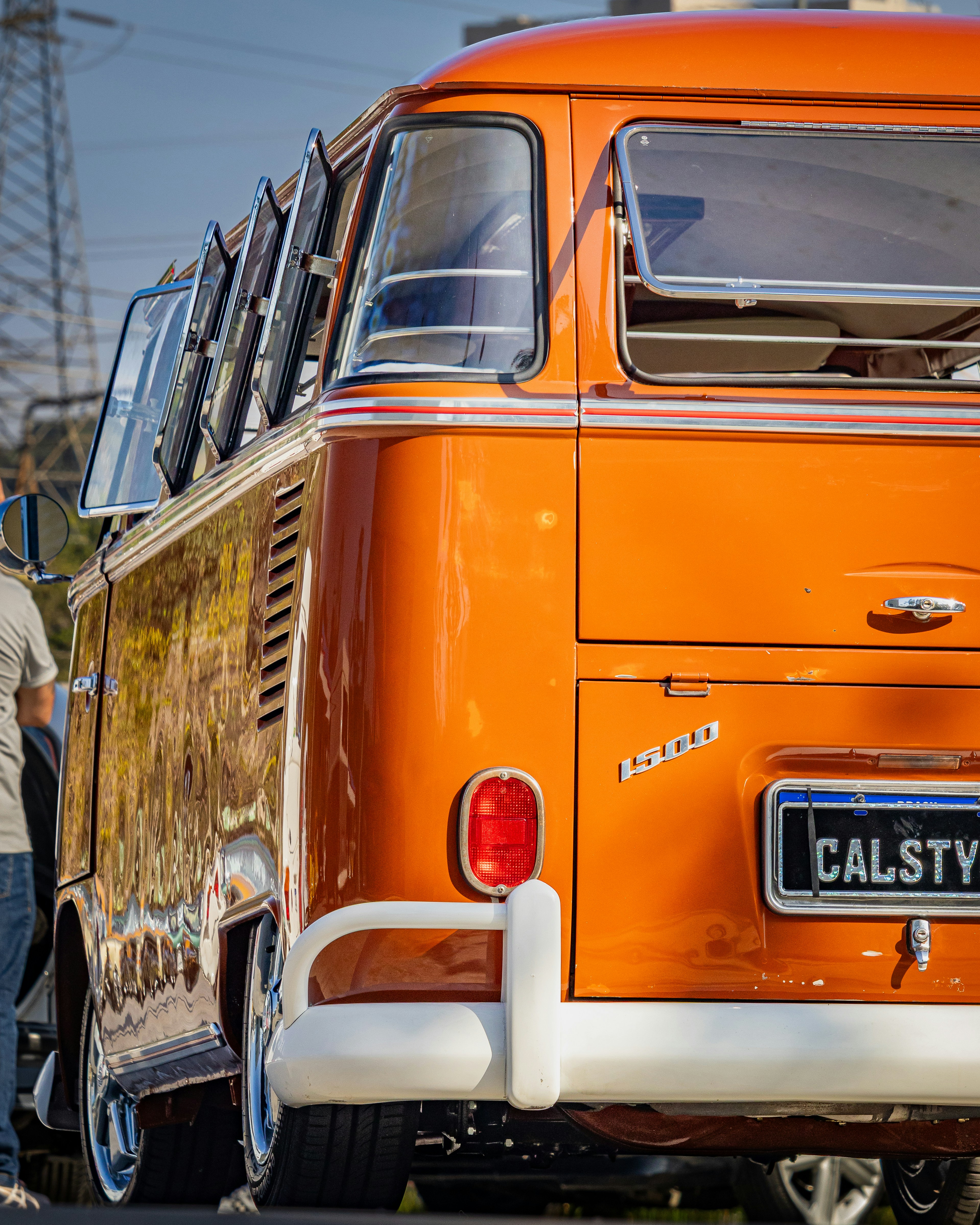 Sunlit Orange Beast: A Classic Bus Basking in Reflection