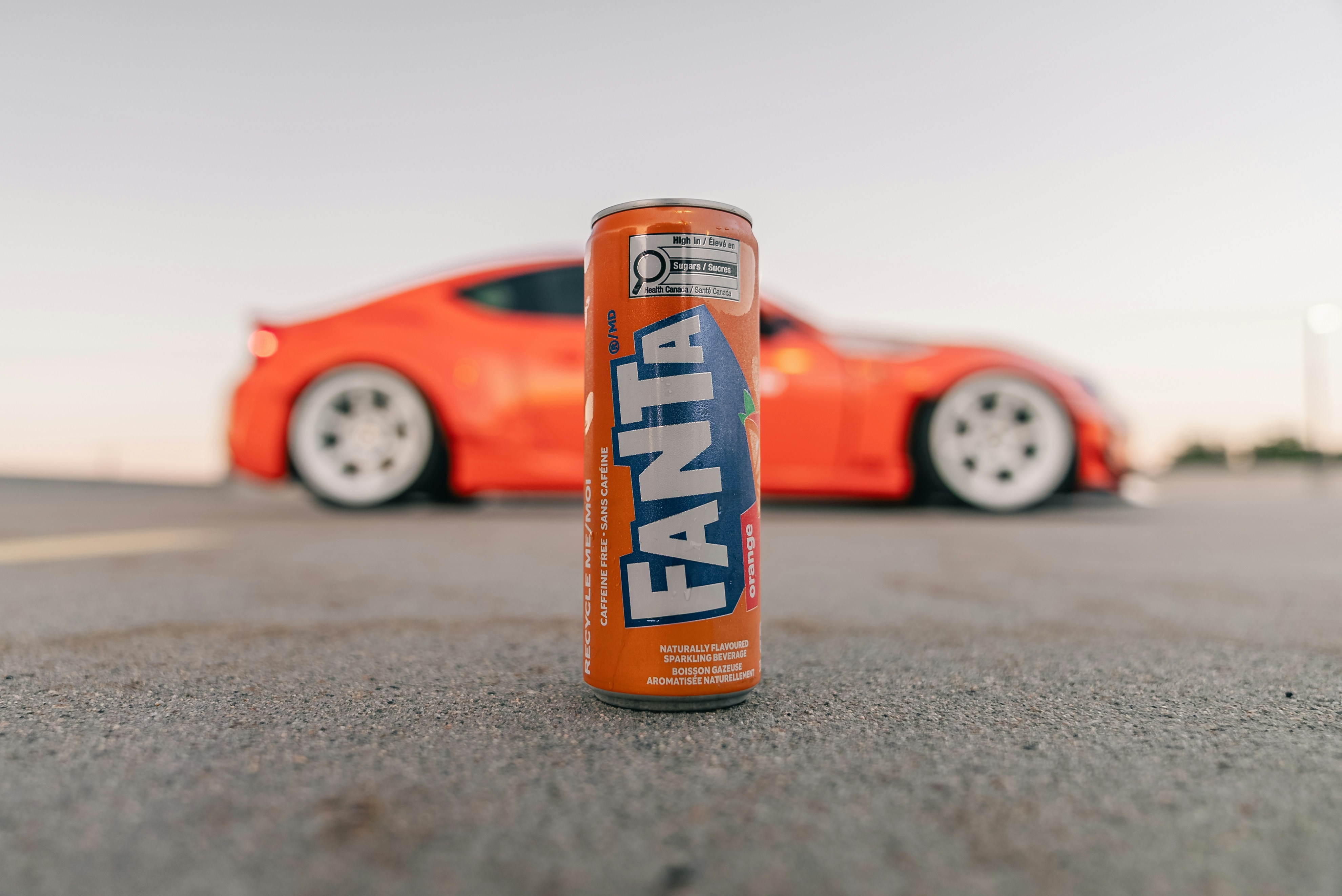 Fanta Can in Focus: Orange Blast on the Tarmac