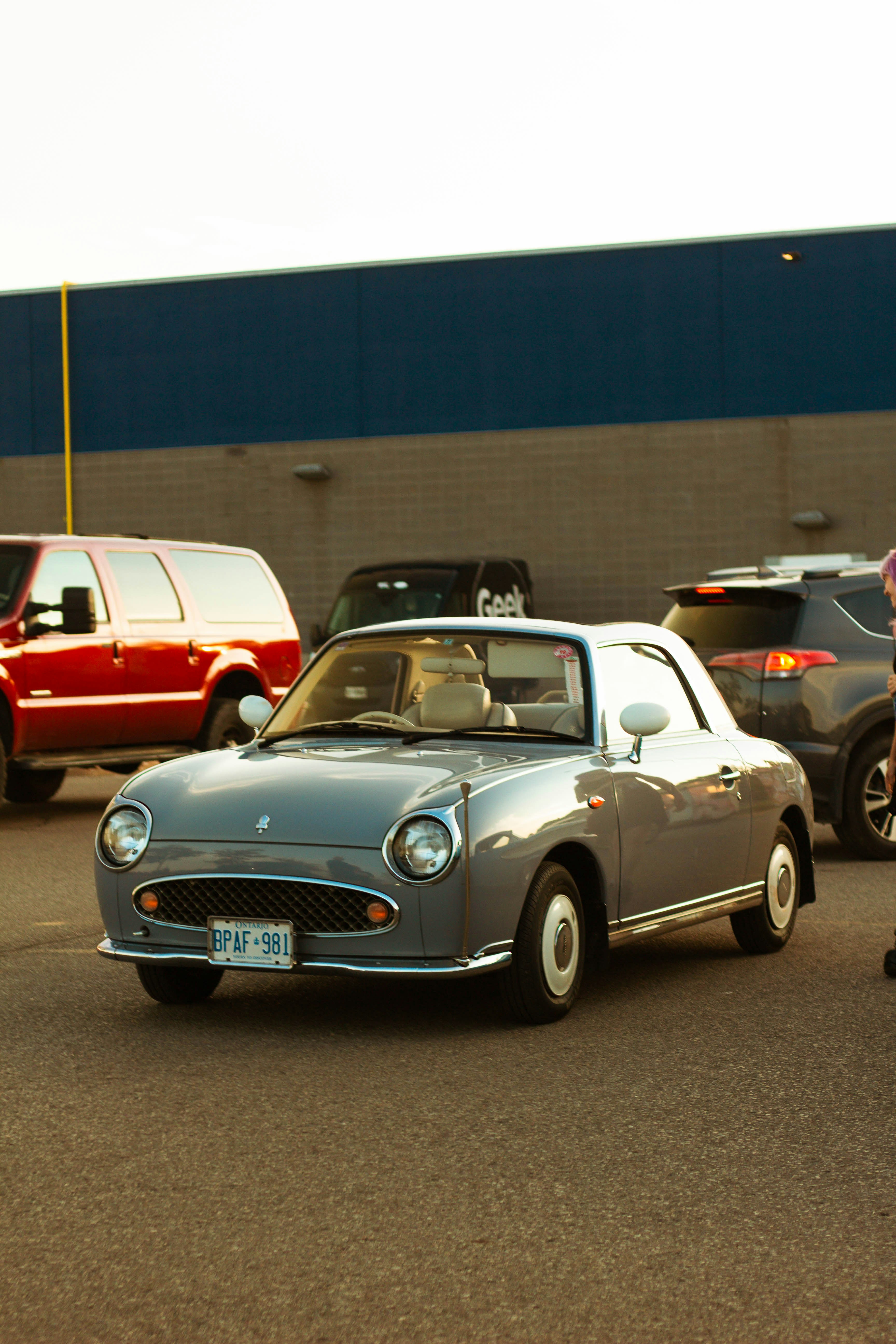 Blue vintage coupe at a sunlit parking lot