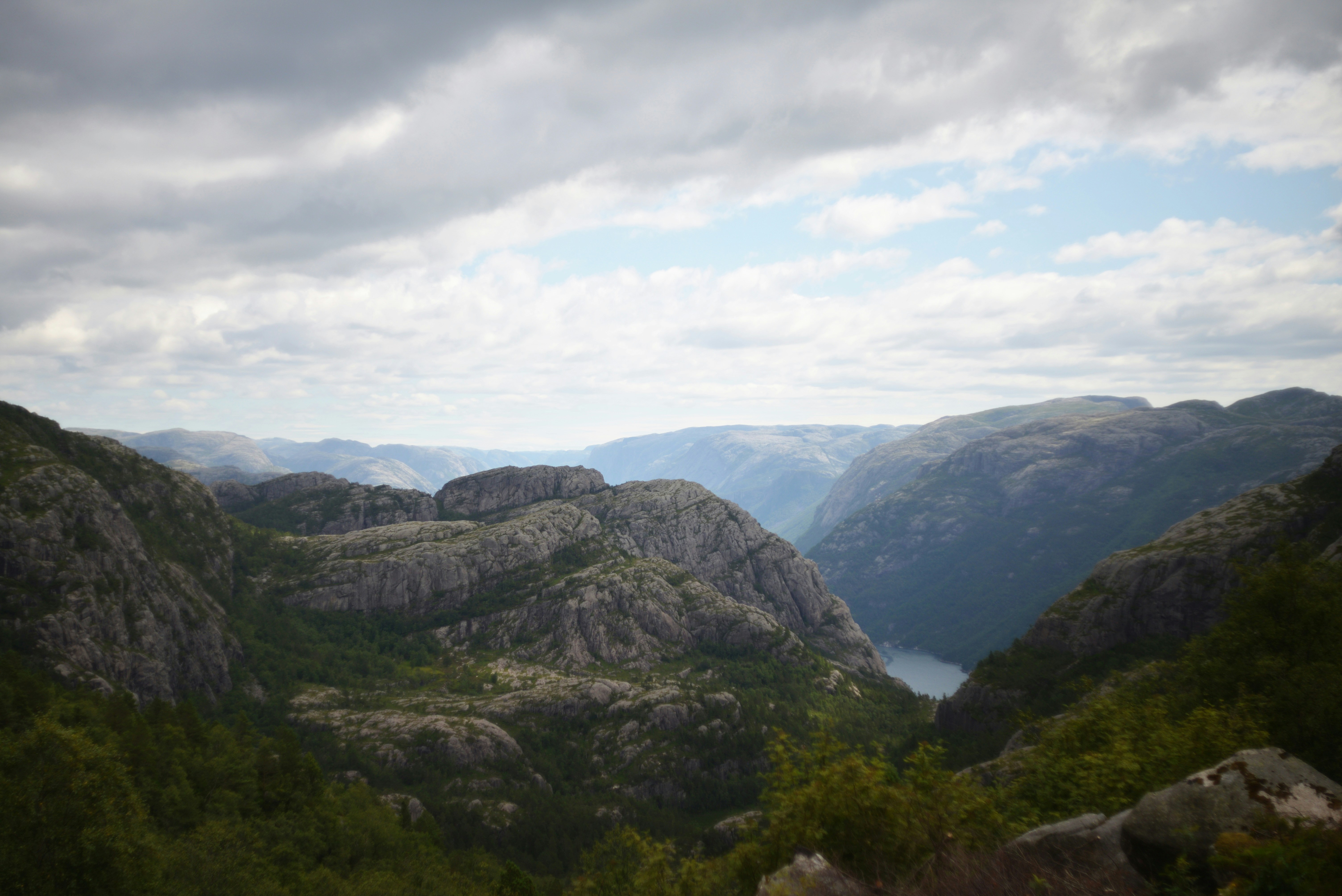 Valley Echoes: Sunlit Ridges Amid Cloud-Covered Fjords