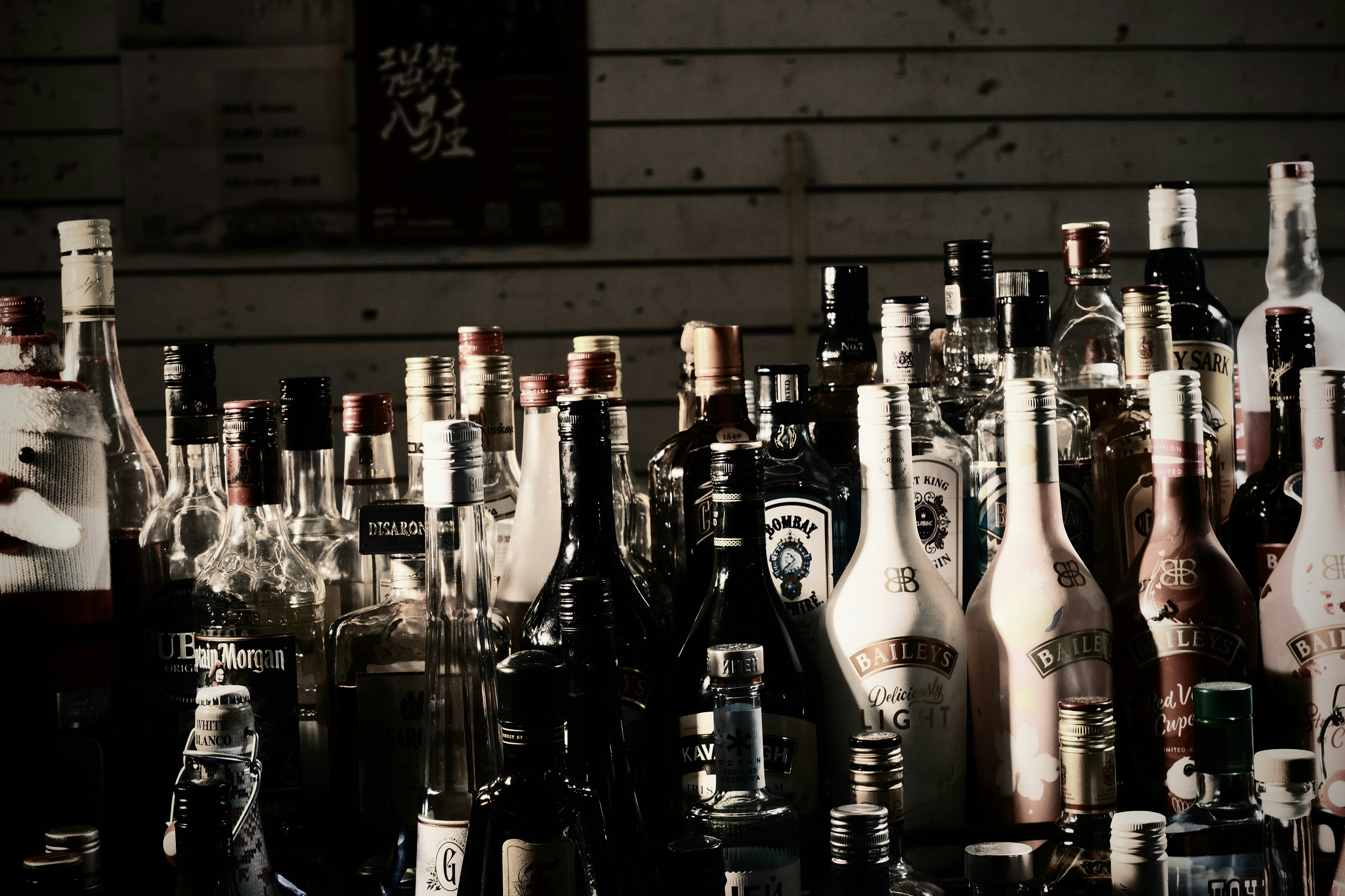 Forbidden Shelf: A Dense Array of Bottles under Dim Bar Light