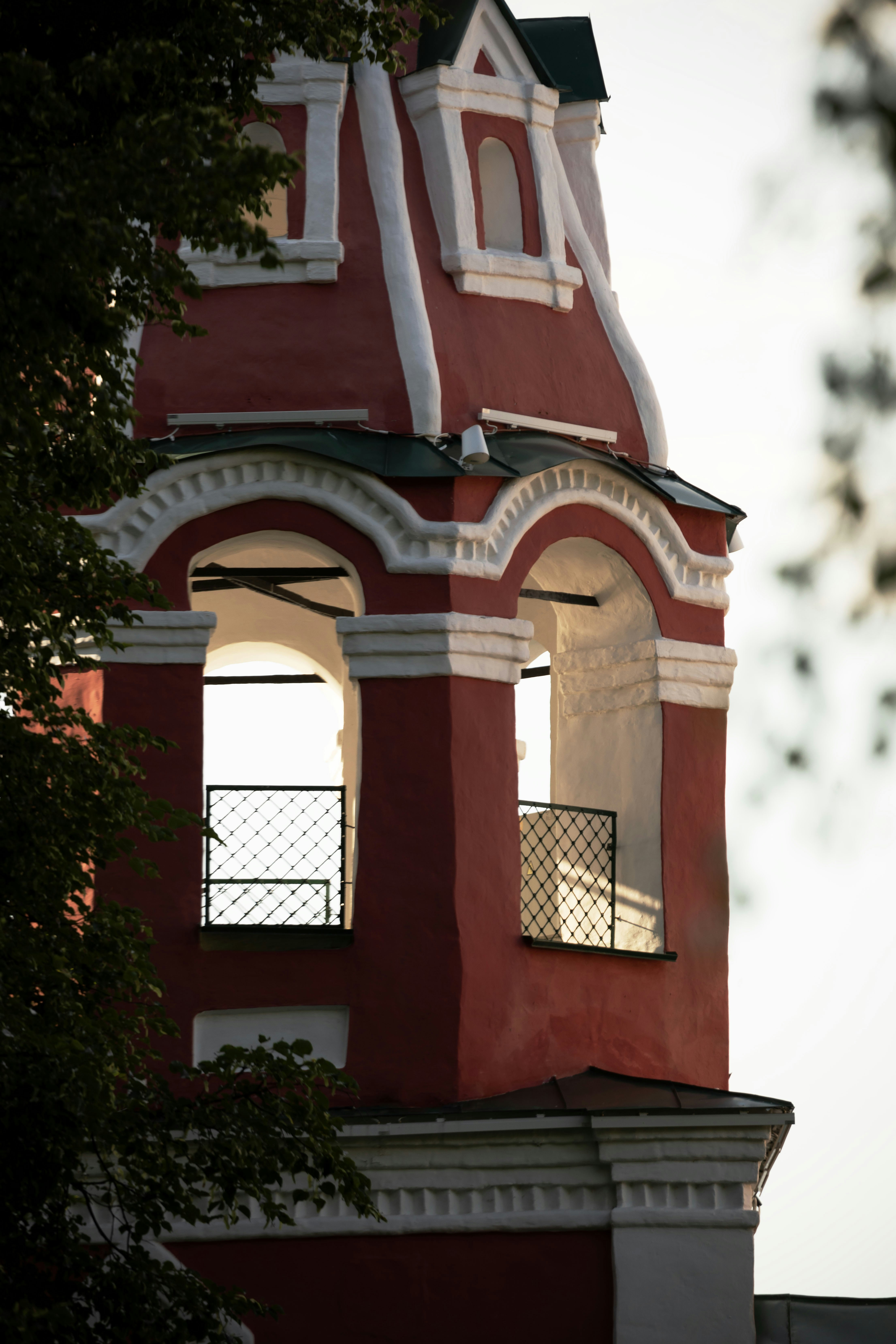 Red Brick Bell Tower Framed by Greenery at Dusk