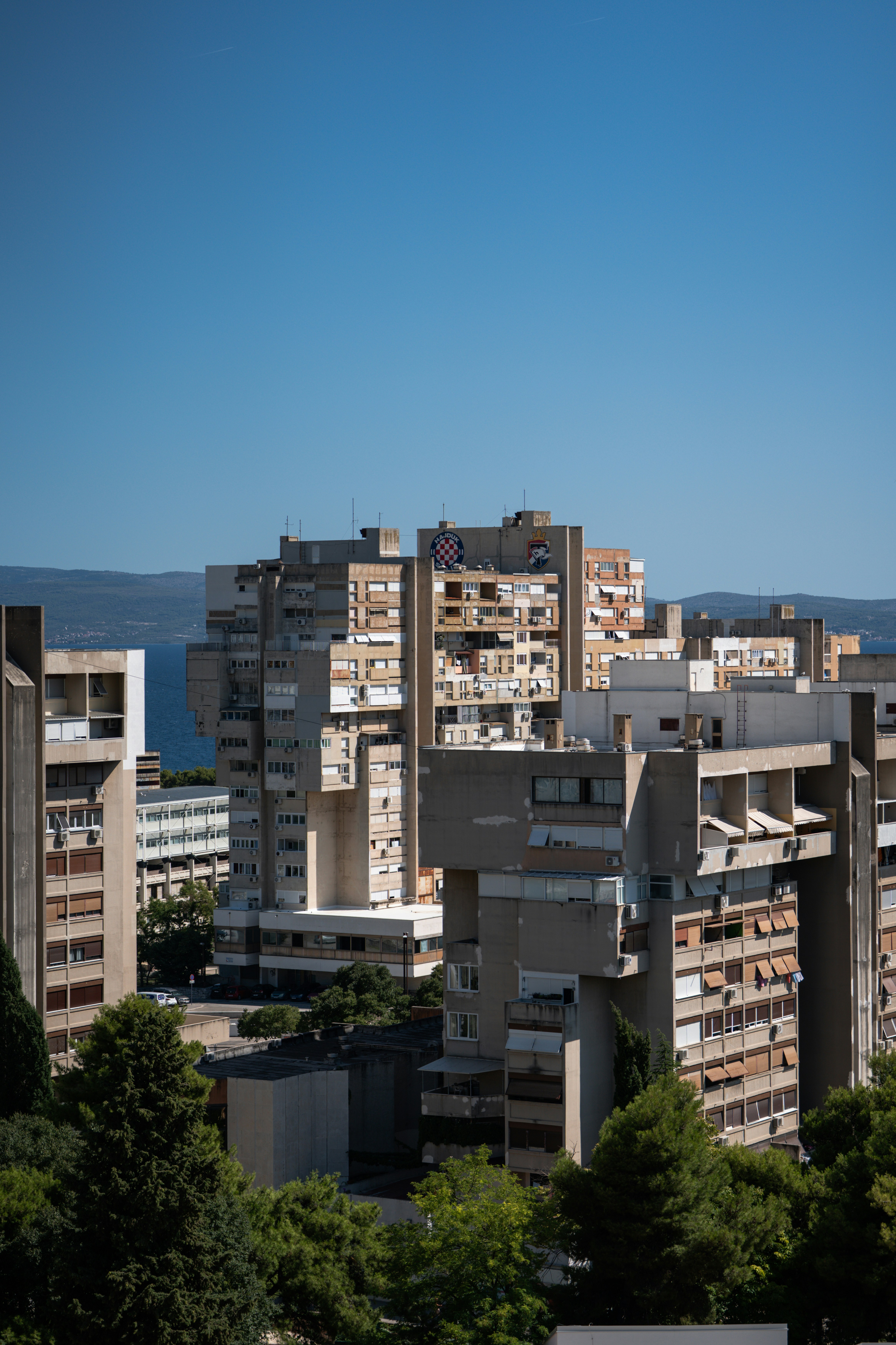 Urban Cascade: Terraced Blocks Rise Above Verdant Canopy