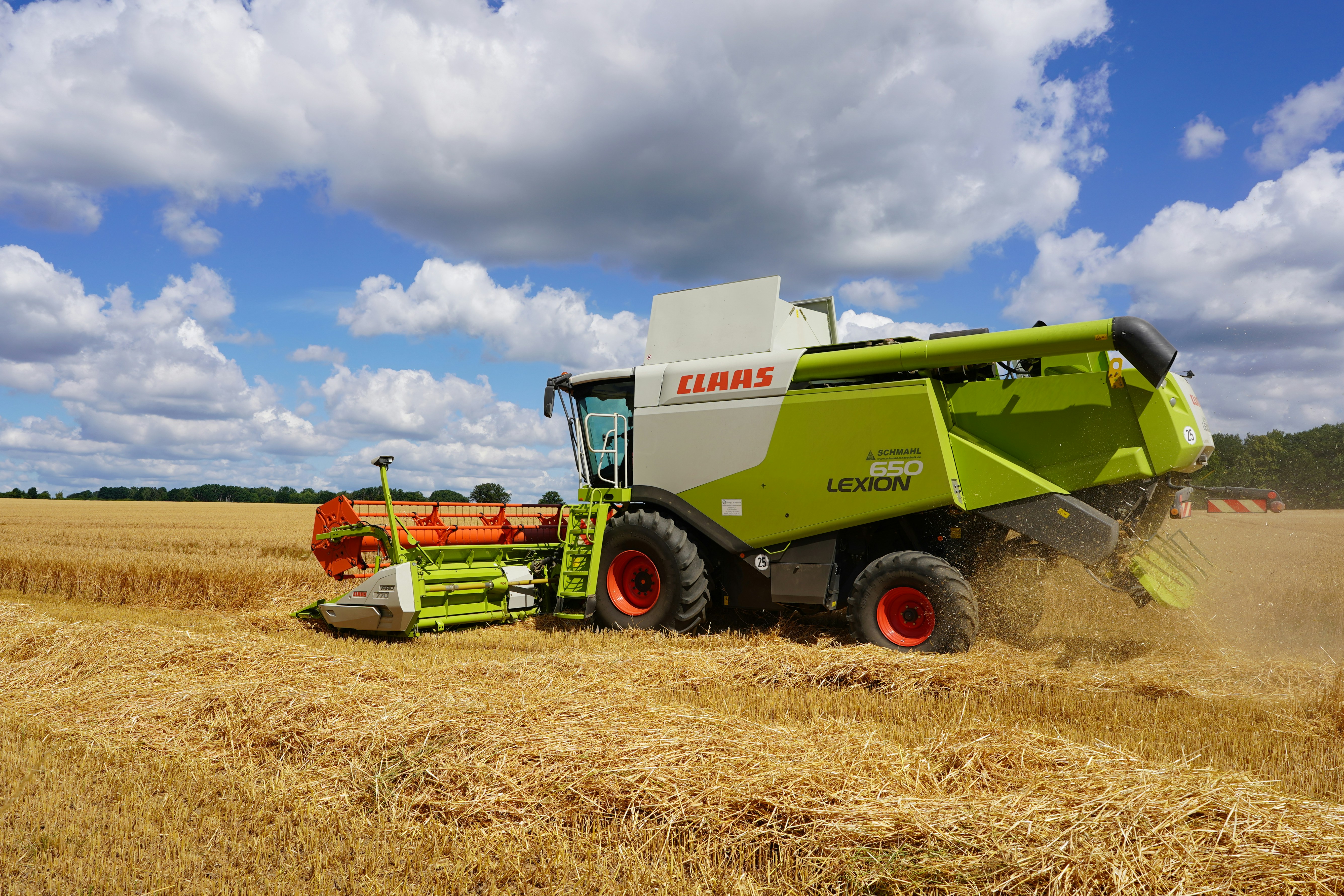 Green Harvester Races Across a Golden Field