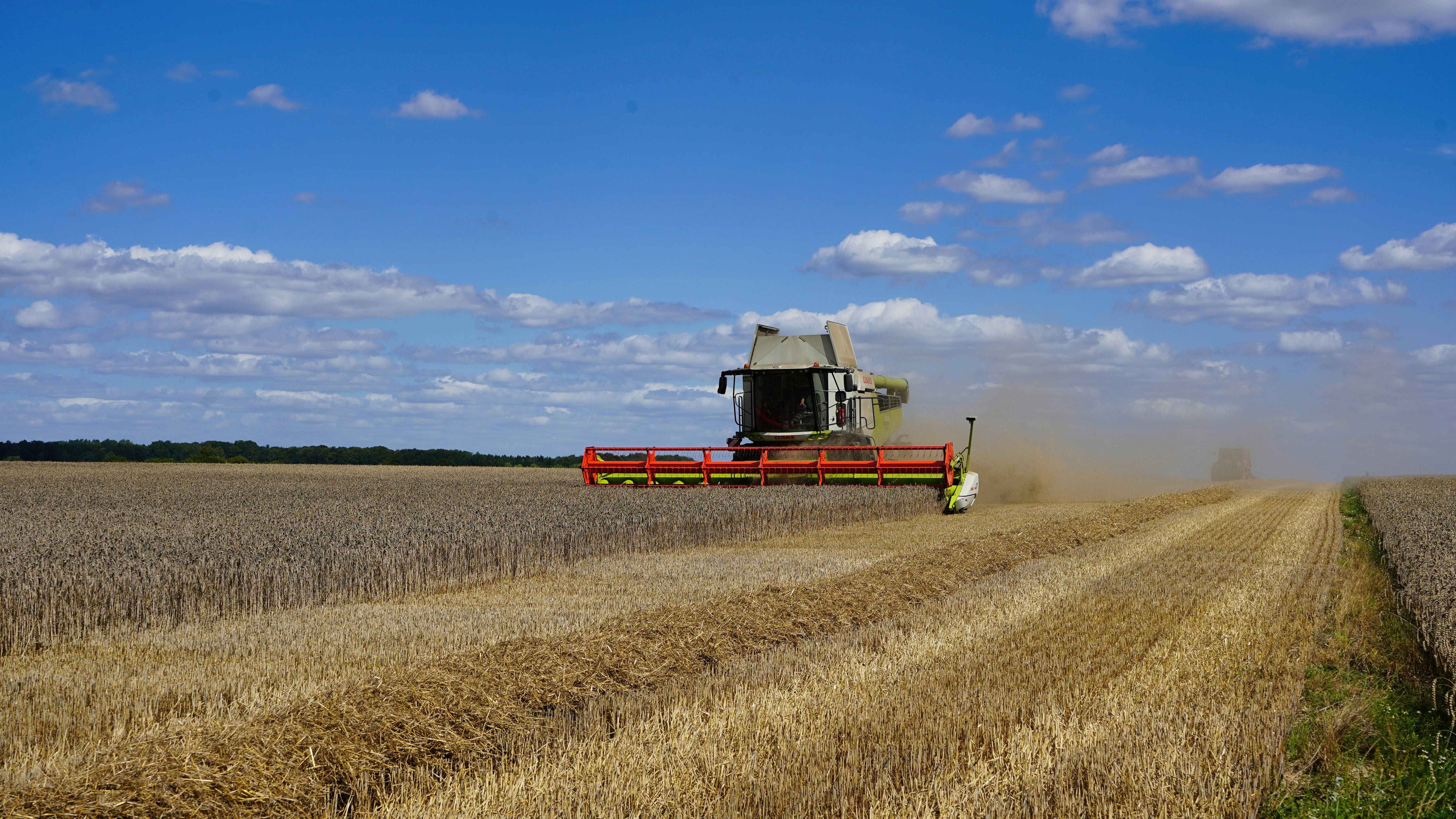 Silhouette of a Harvester Ripping Through a Golden Harvest