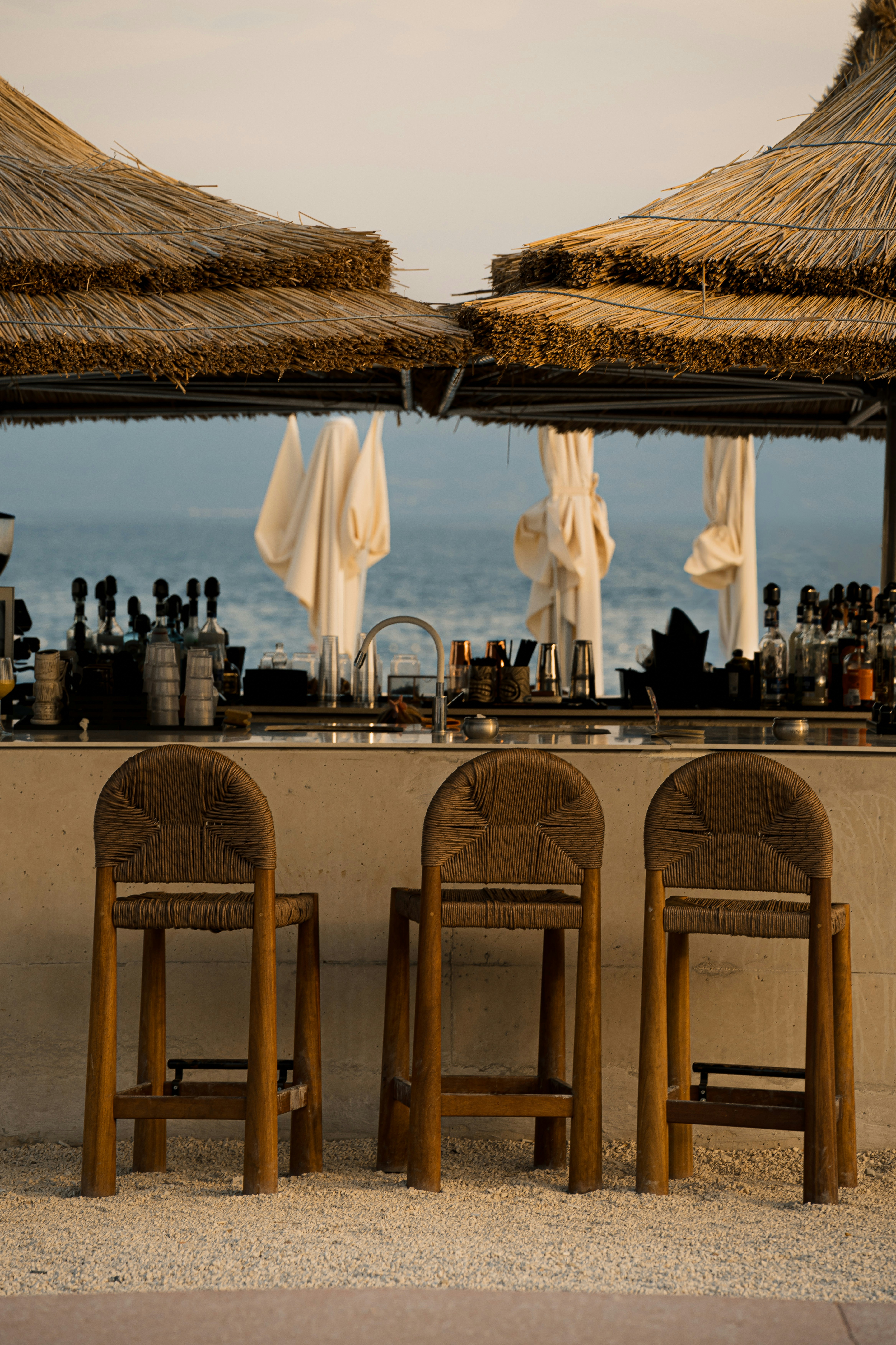 Bar Counter by the Sea: Empty Stools, Sunset Over Tiki Roofs