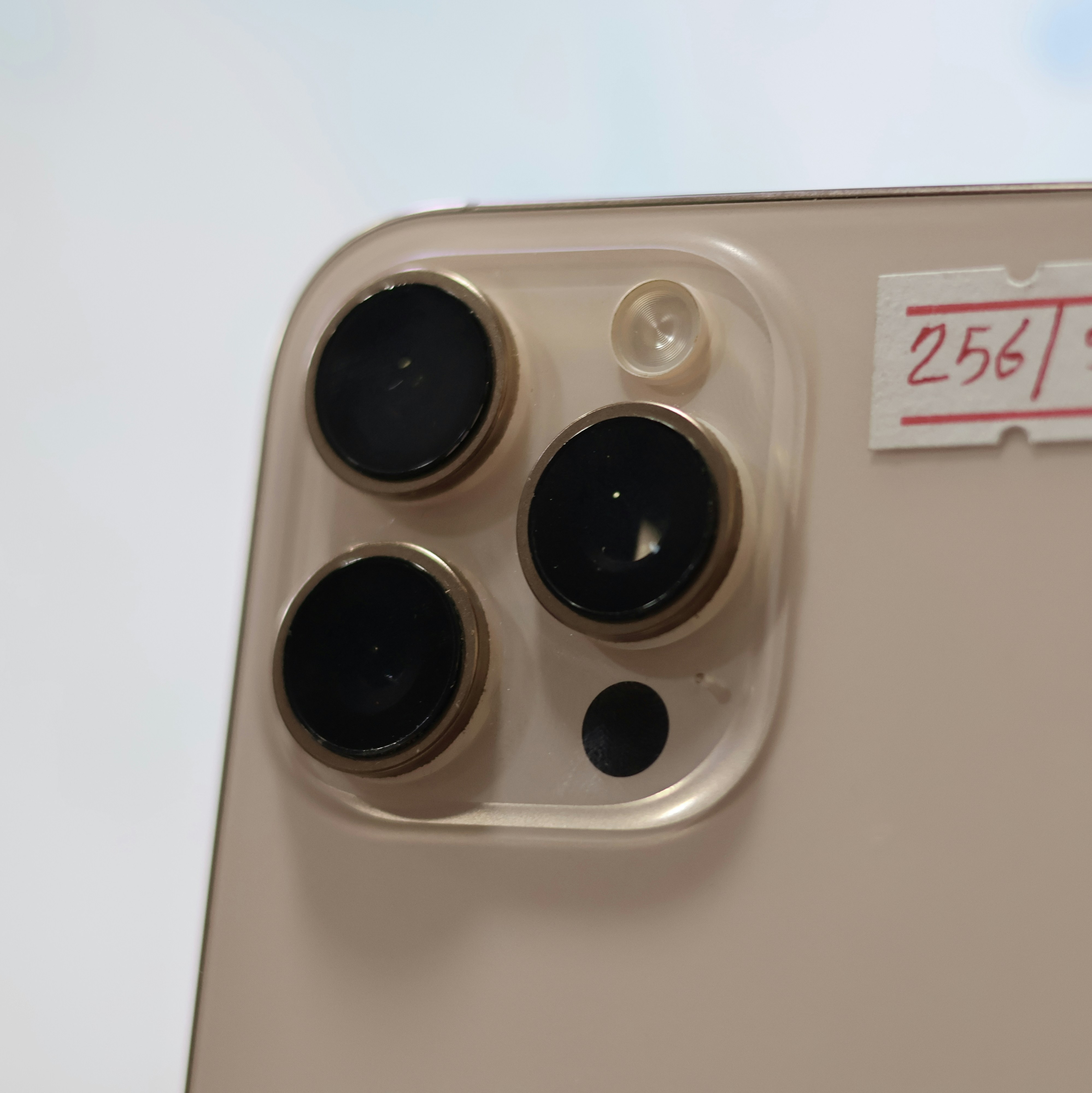 Triple-Lens Corner: A Beige iPhone Camera Module with Soft Focus