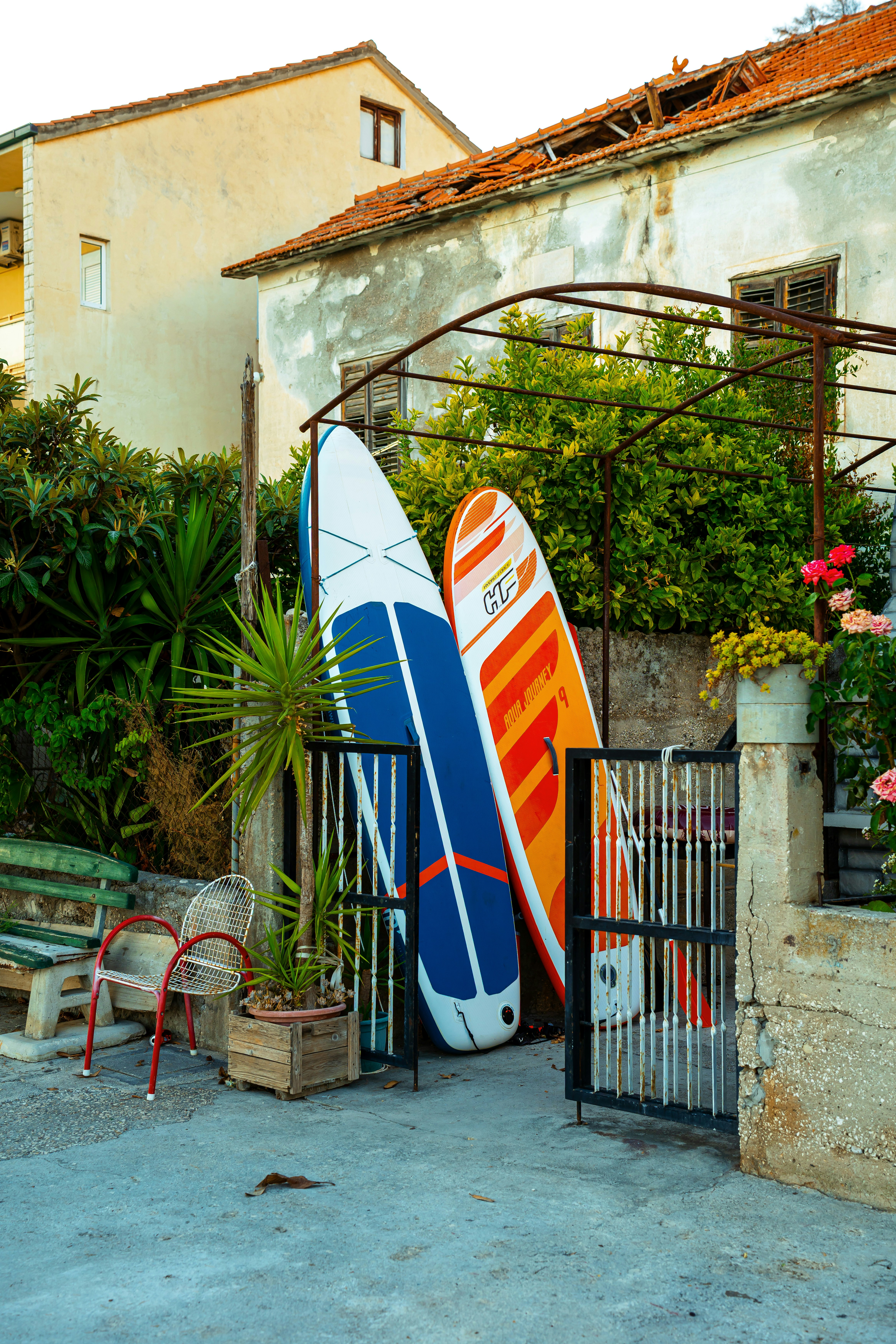 Surfboards Resting by a Garden Gate