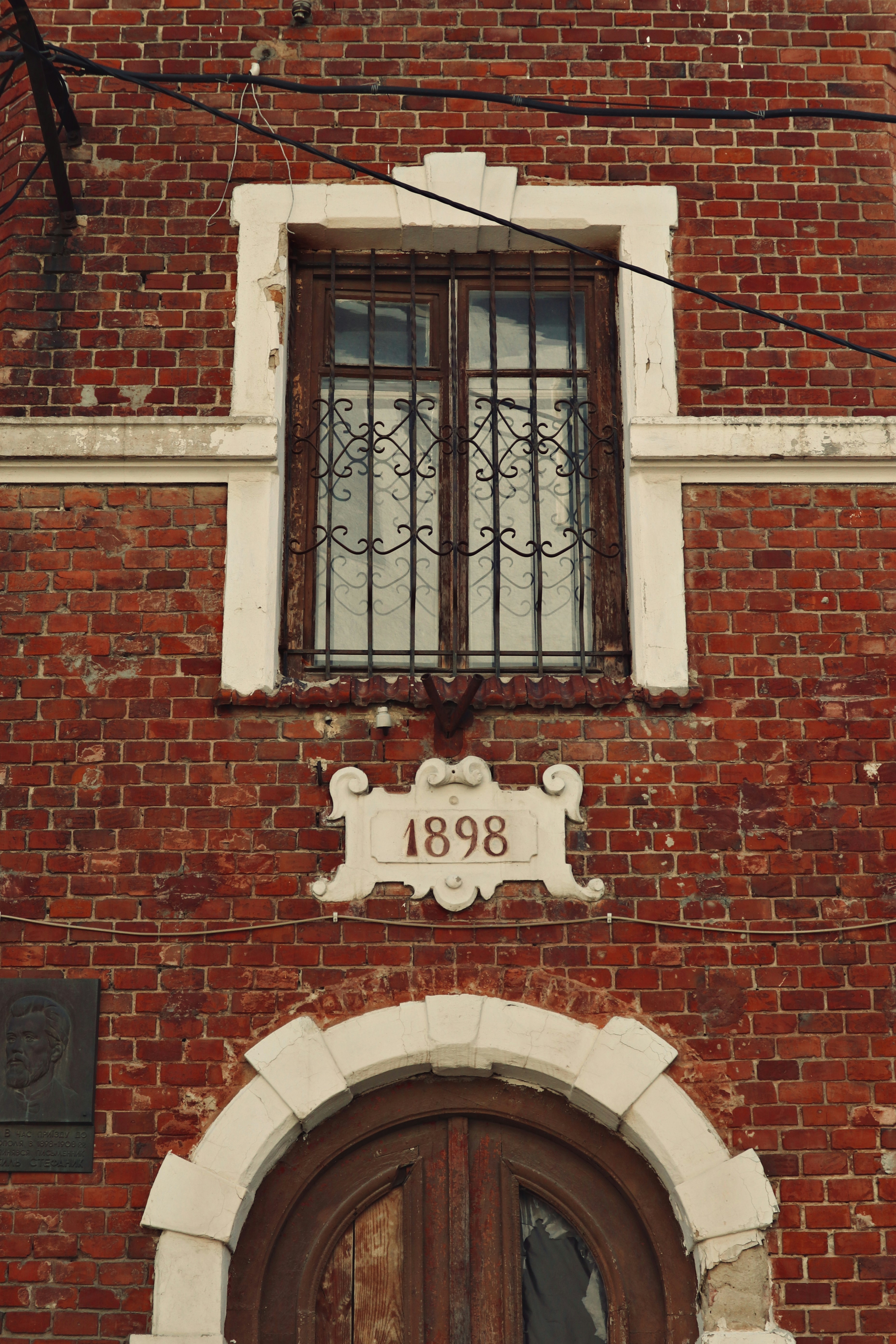 Brick Facade Chronicle: The 1898 Window with Wrought Iron Veil