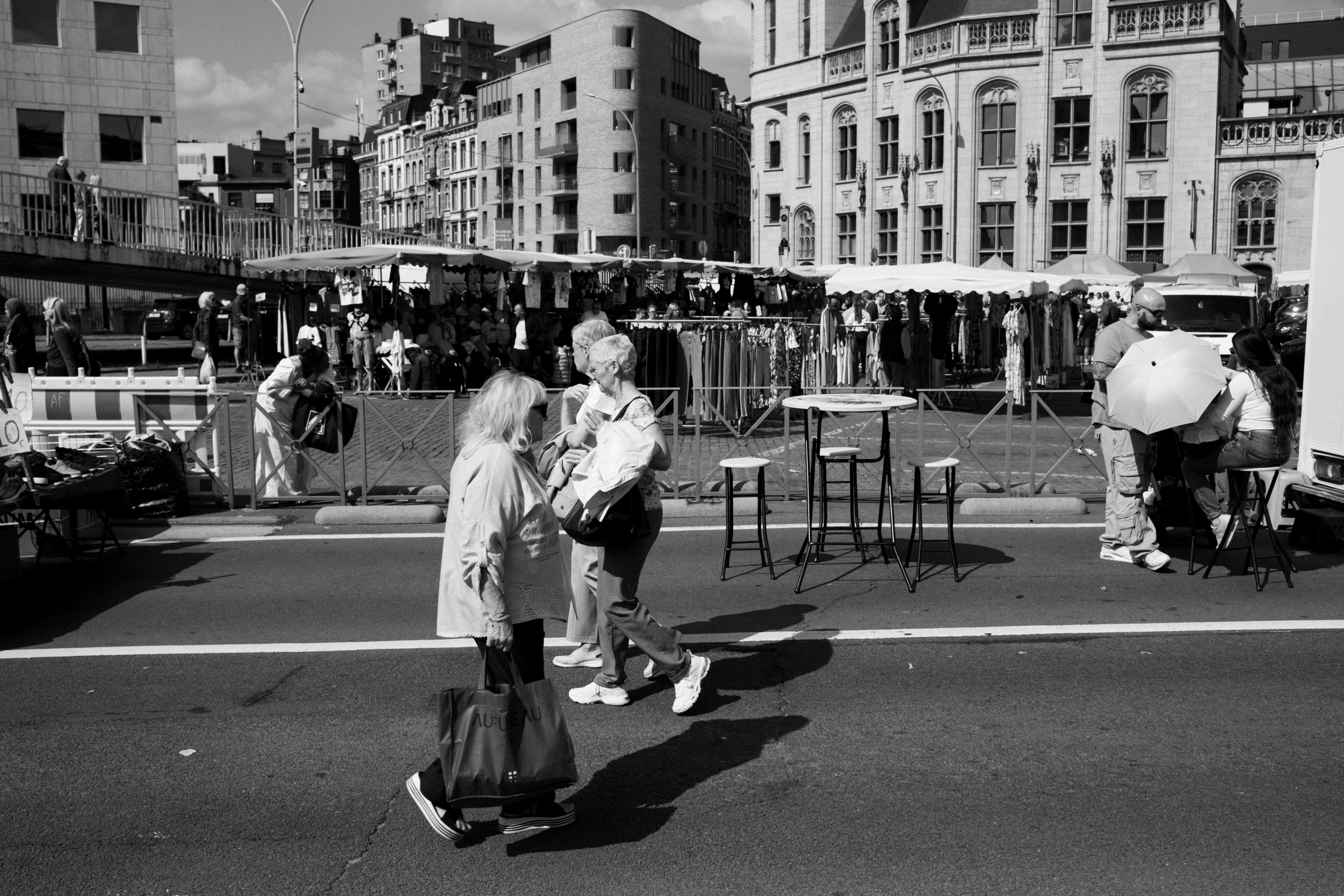 Crossing Moments: City Street Amid Market Stalls