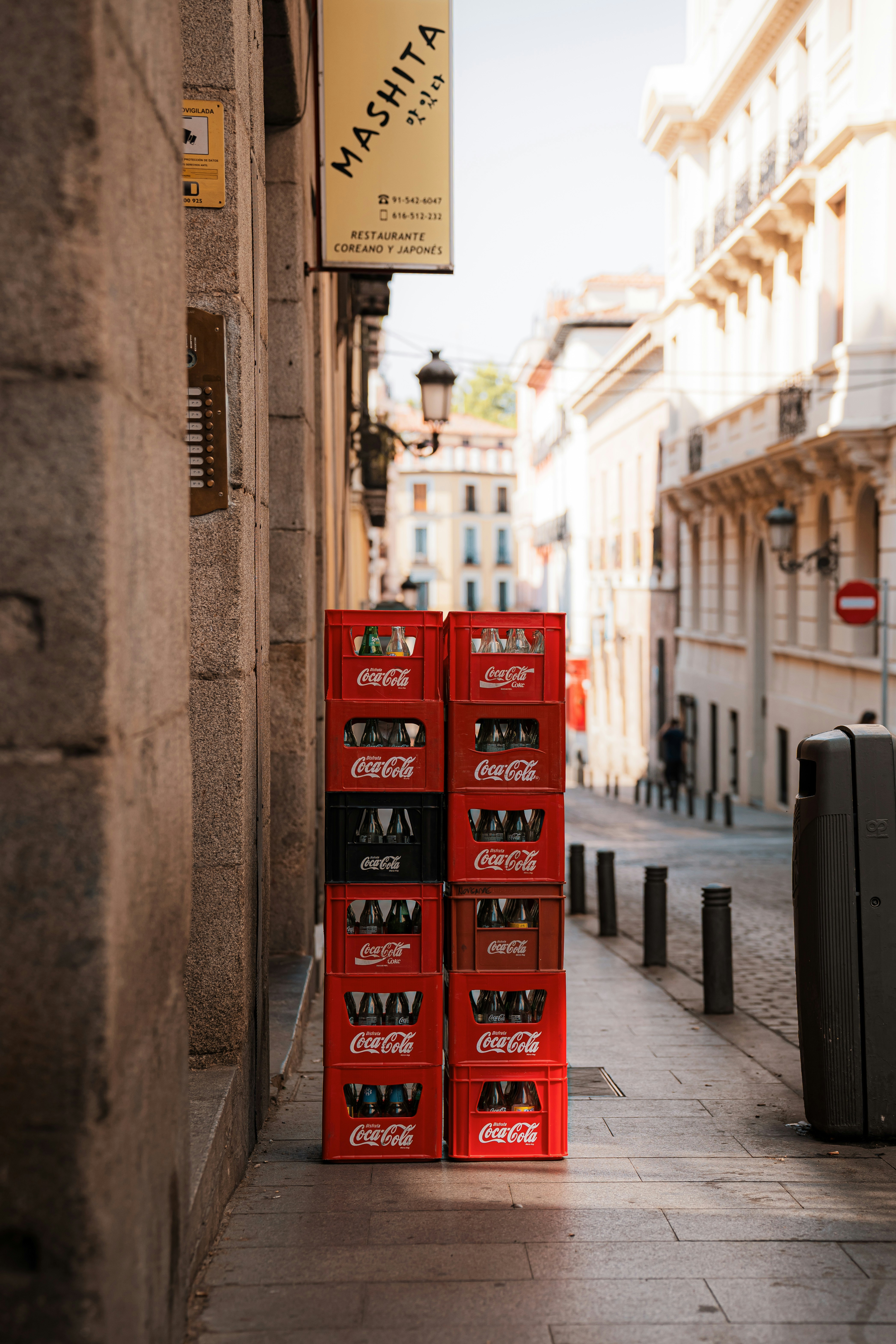 Crimson Beverage Stack Anchoring a Narrow European Street