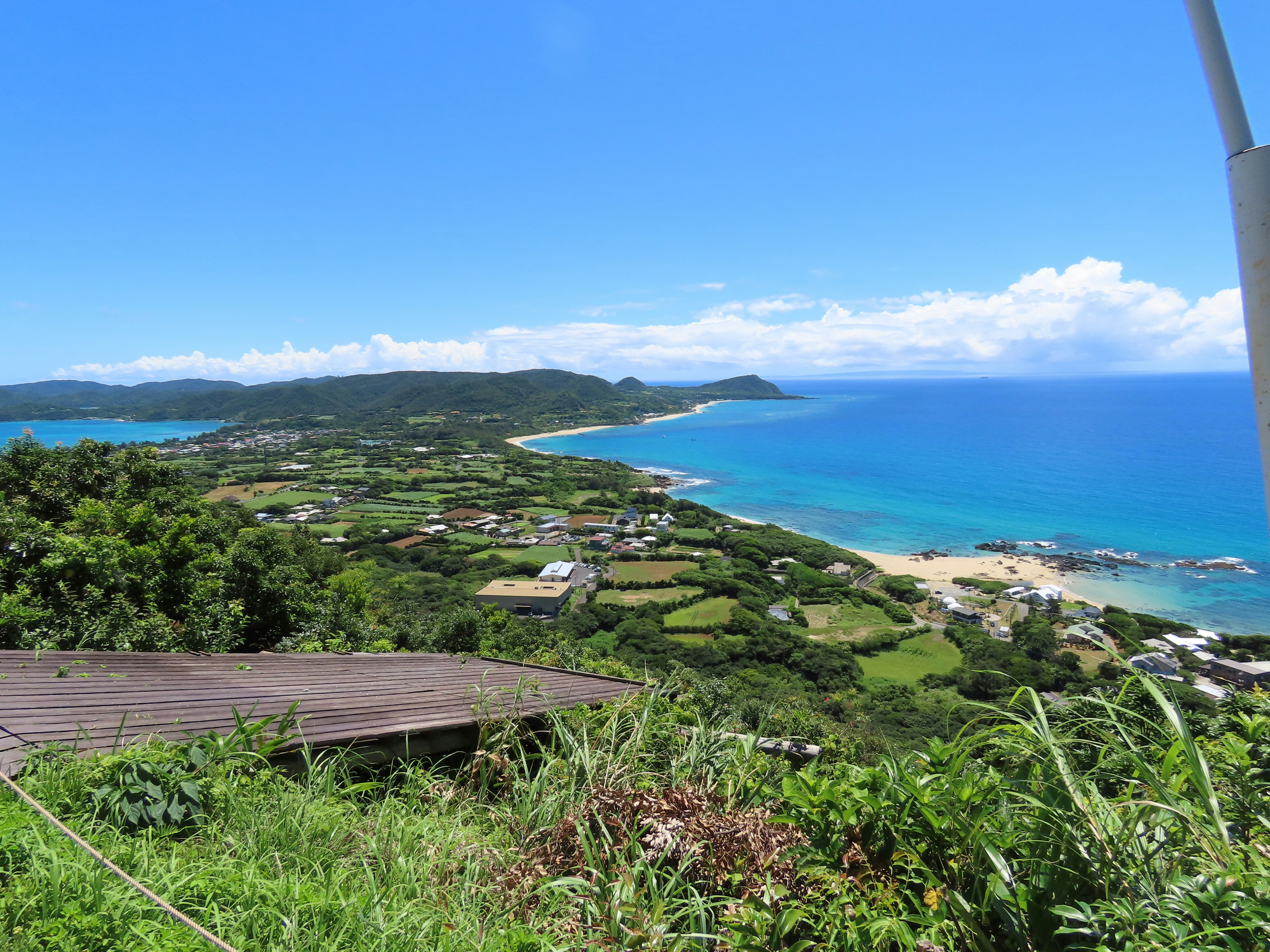 Sunlit Cape Vicinity: A Coastal Village Embraced by Turquoise Waters