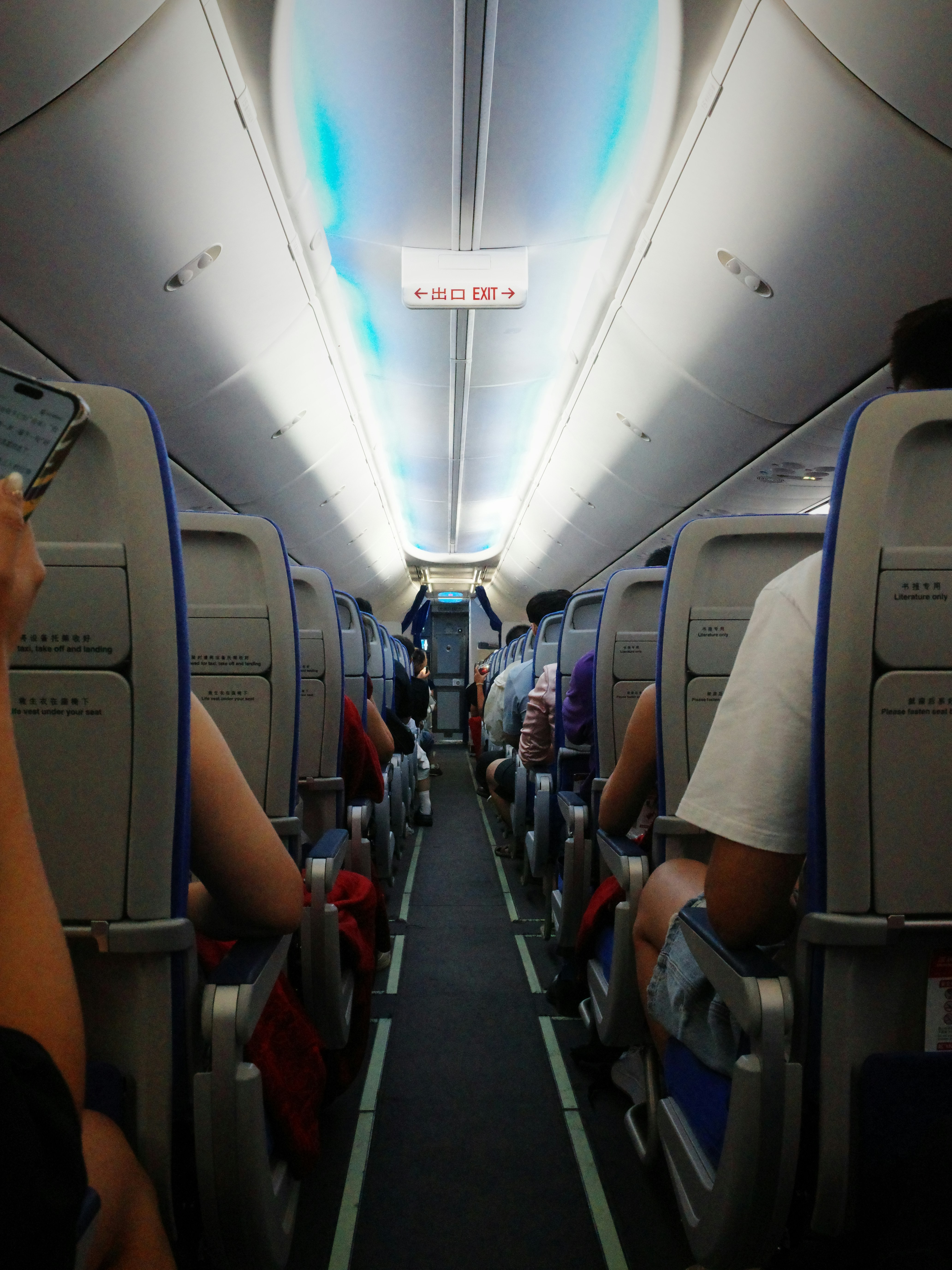 Aisle View: passengers settle into a narrow aircraft corridor