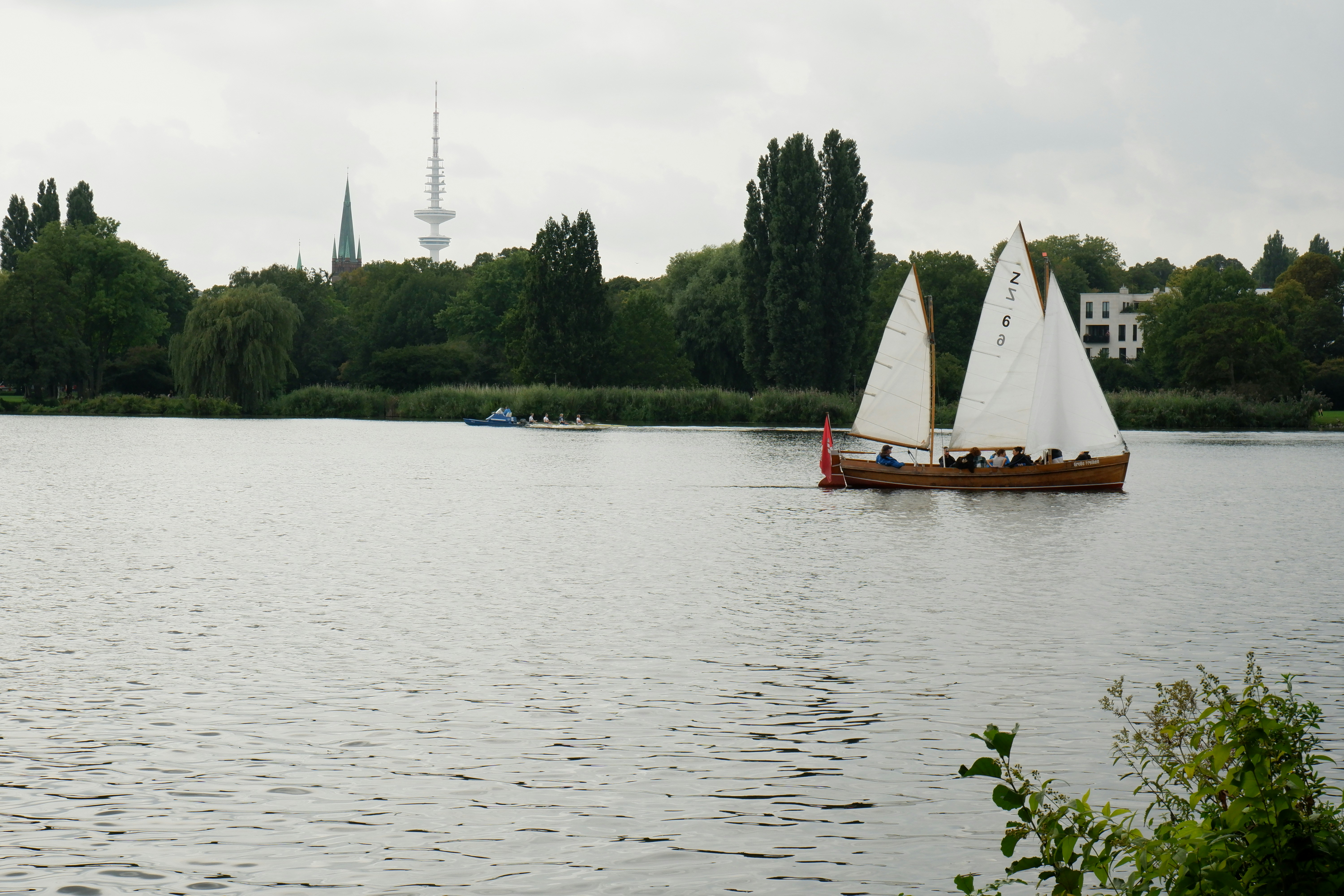 Sailing along the river under a calm, overcast sky