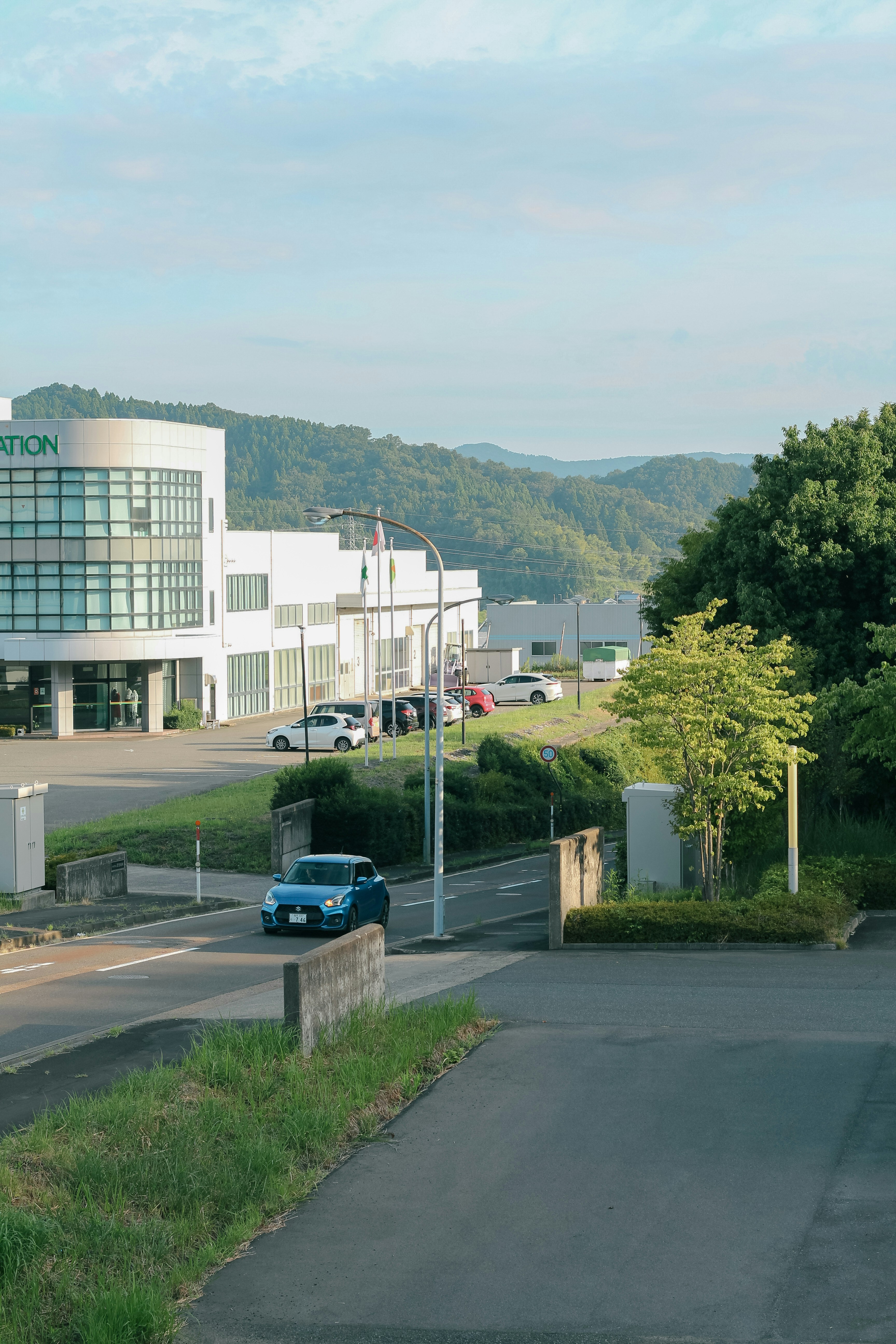 Facade and Roadway Lead Toward a Sunlit Corporate Campus