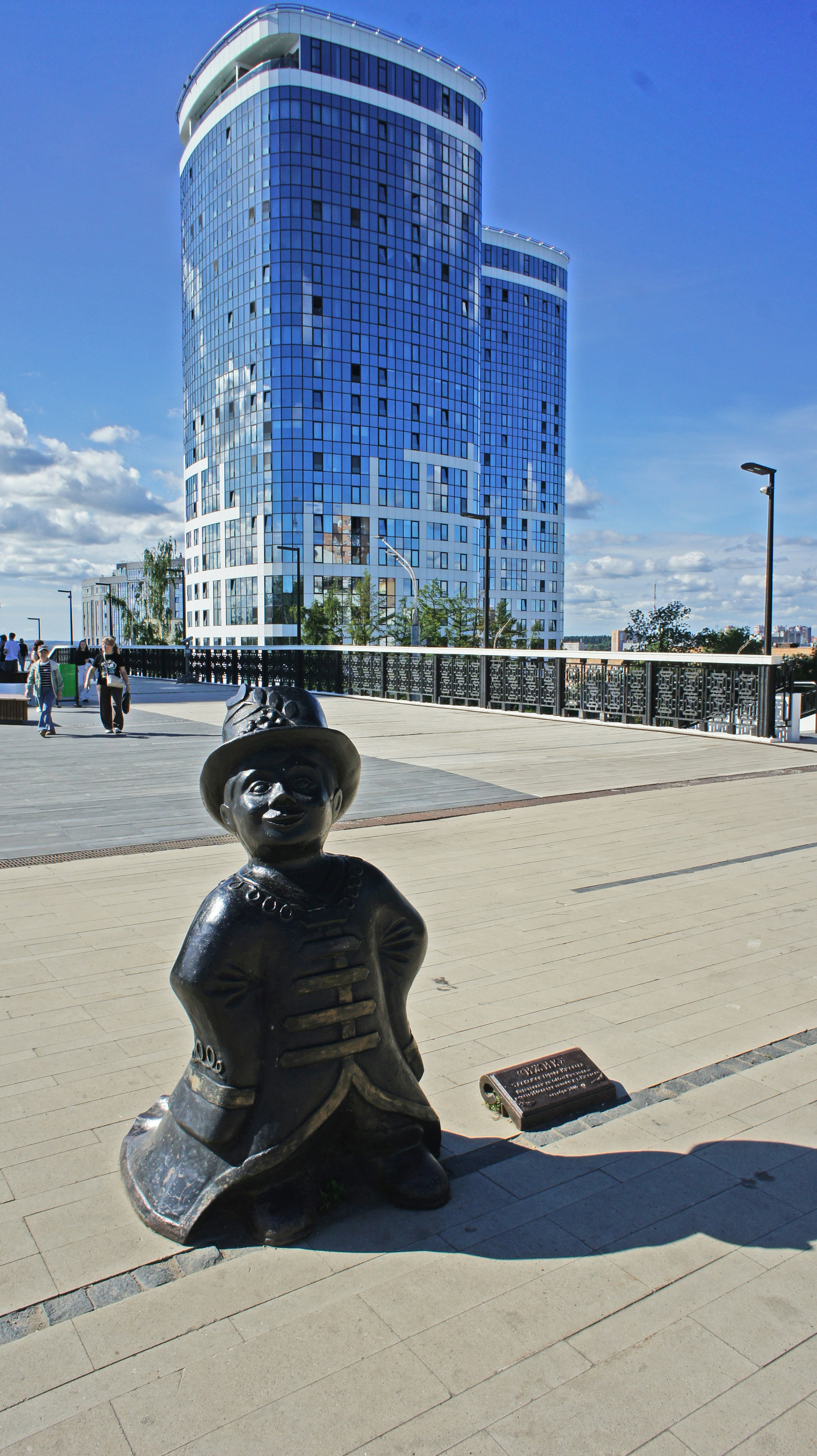 Statue in the Foreground, Modern Glass Towers Rising Beyond