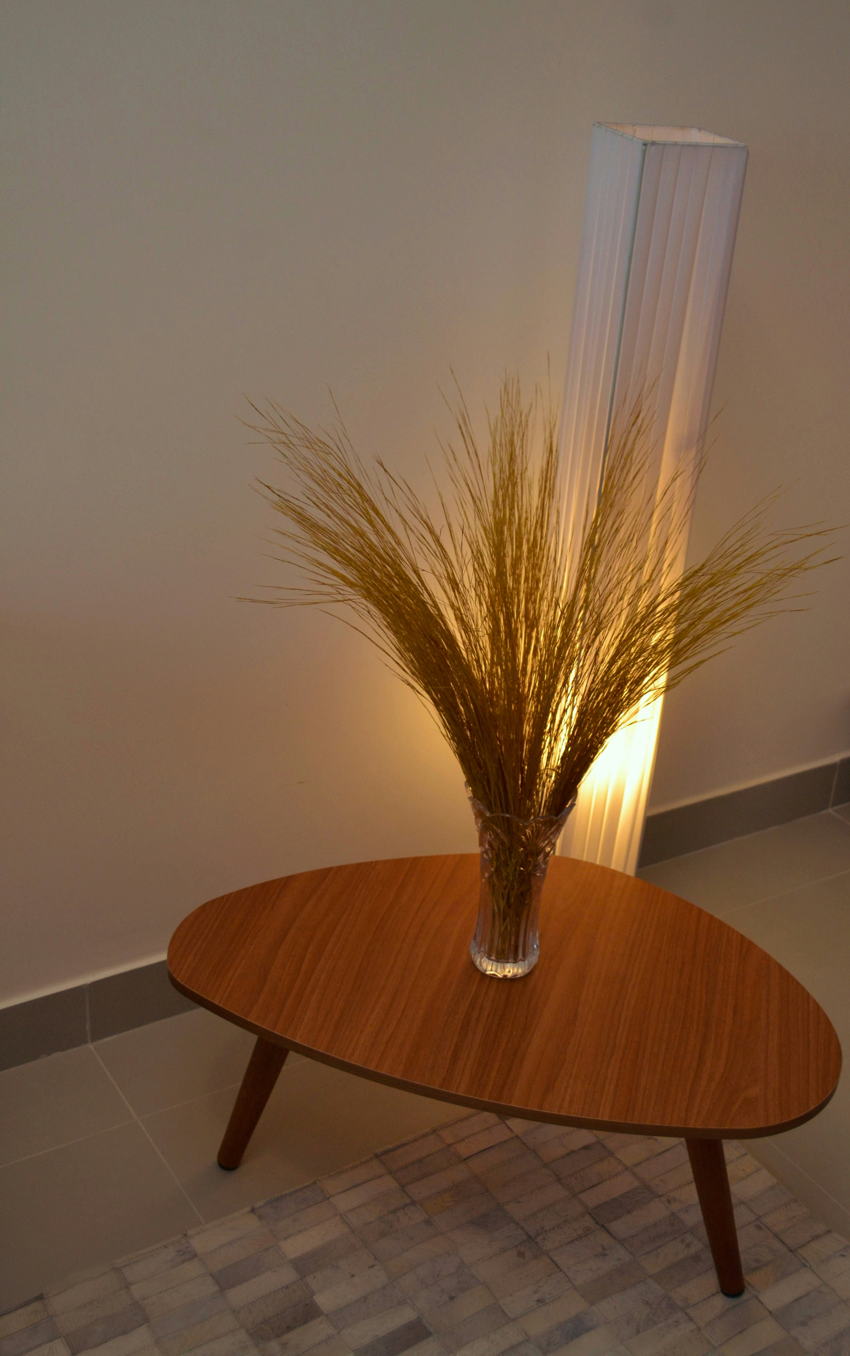 Tall reed bouquet on a mid-century coffee table with backlit lamp