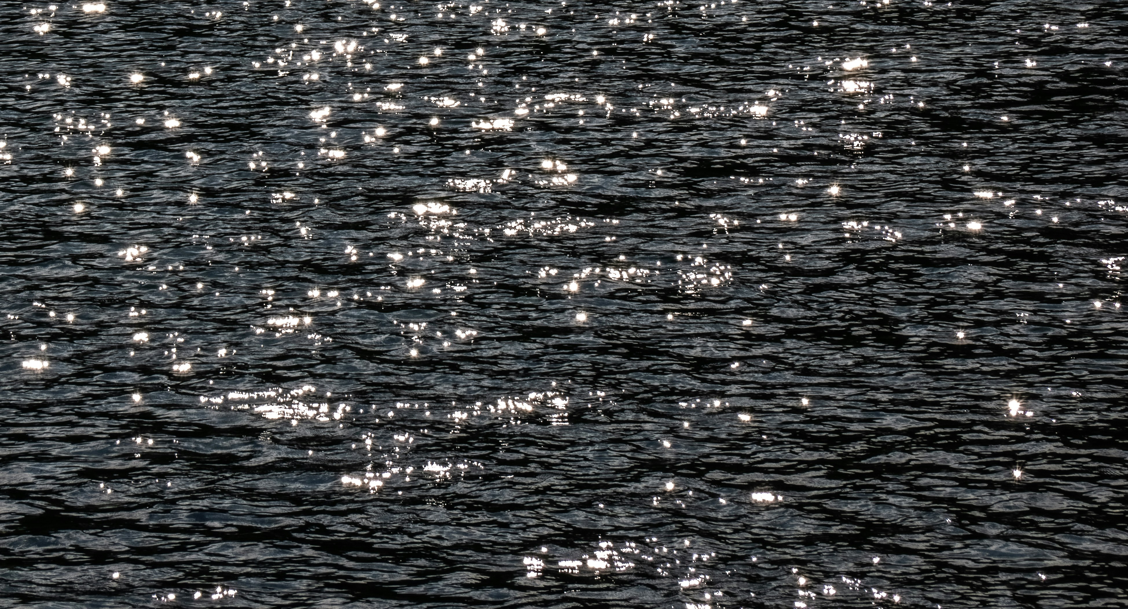Glittering Ripples: Sunlit Sparks on Quiet Water