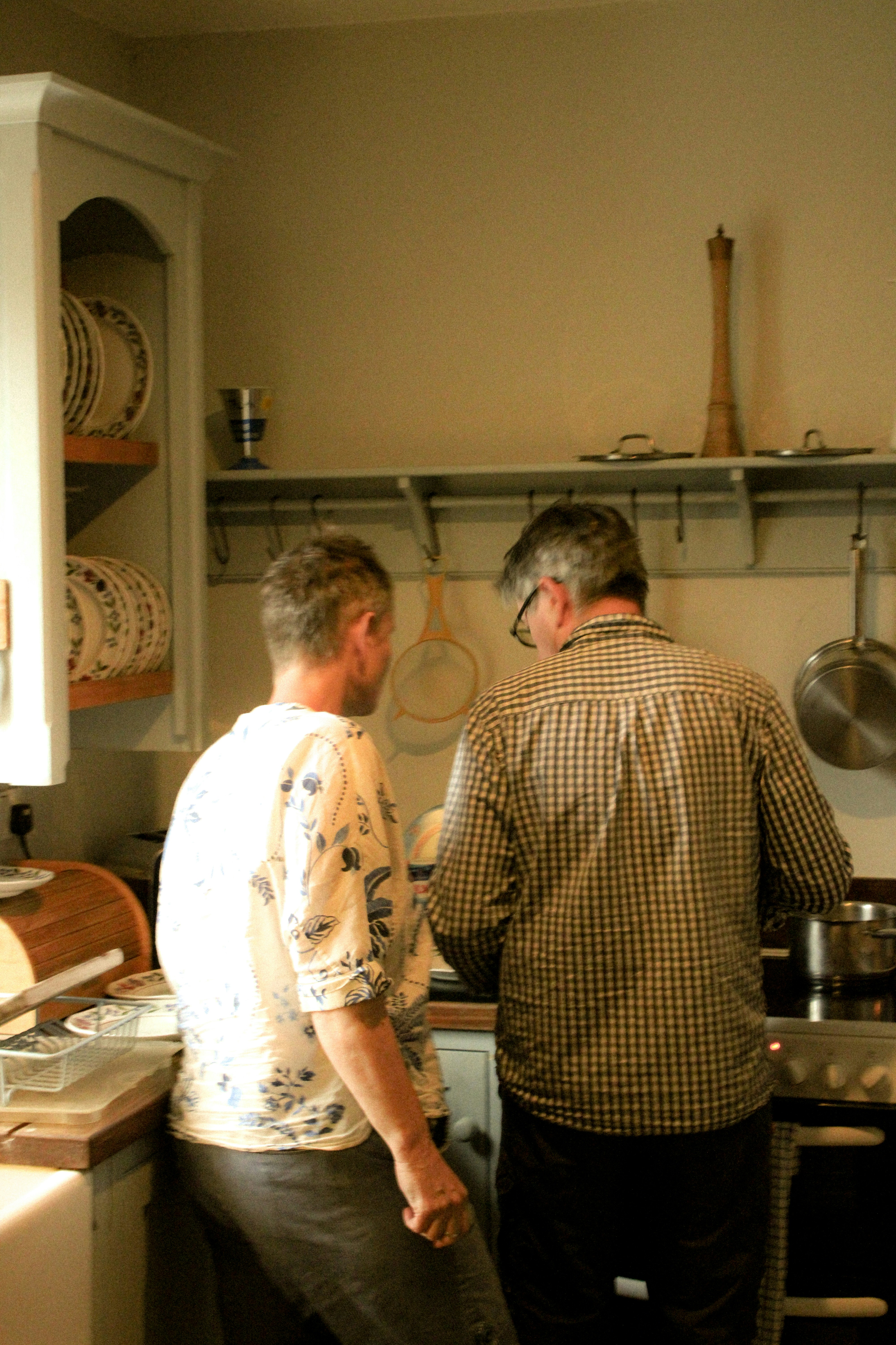 Two Chefs in Quiet Kitchen: Shared Focus Over the Stove
