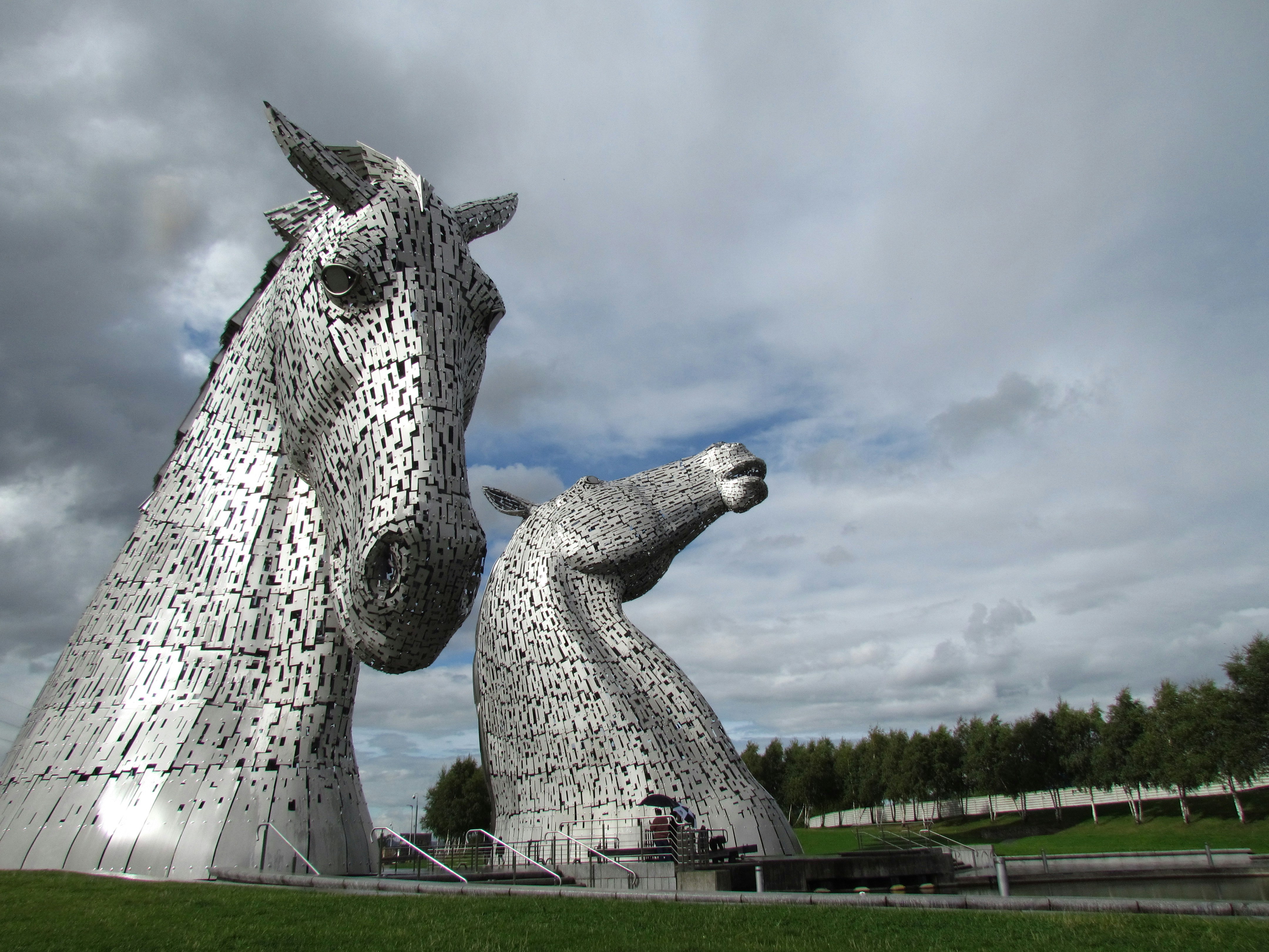 Industrial Stallions: Two Metallic Horses Crowned in a Skyward Meadow