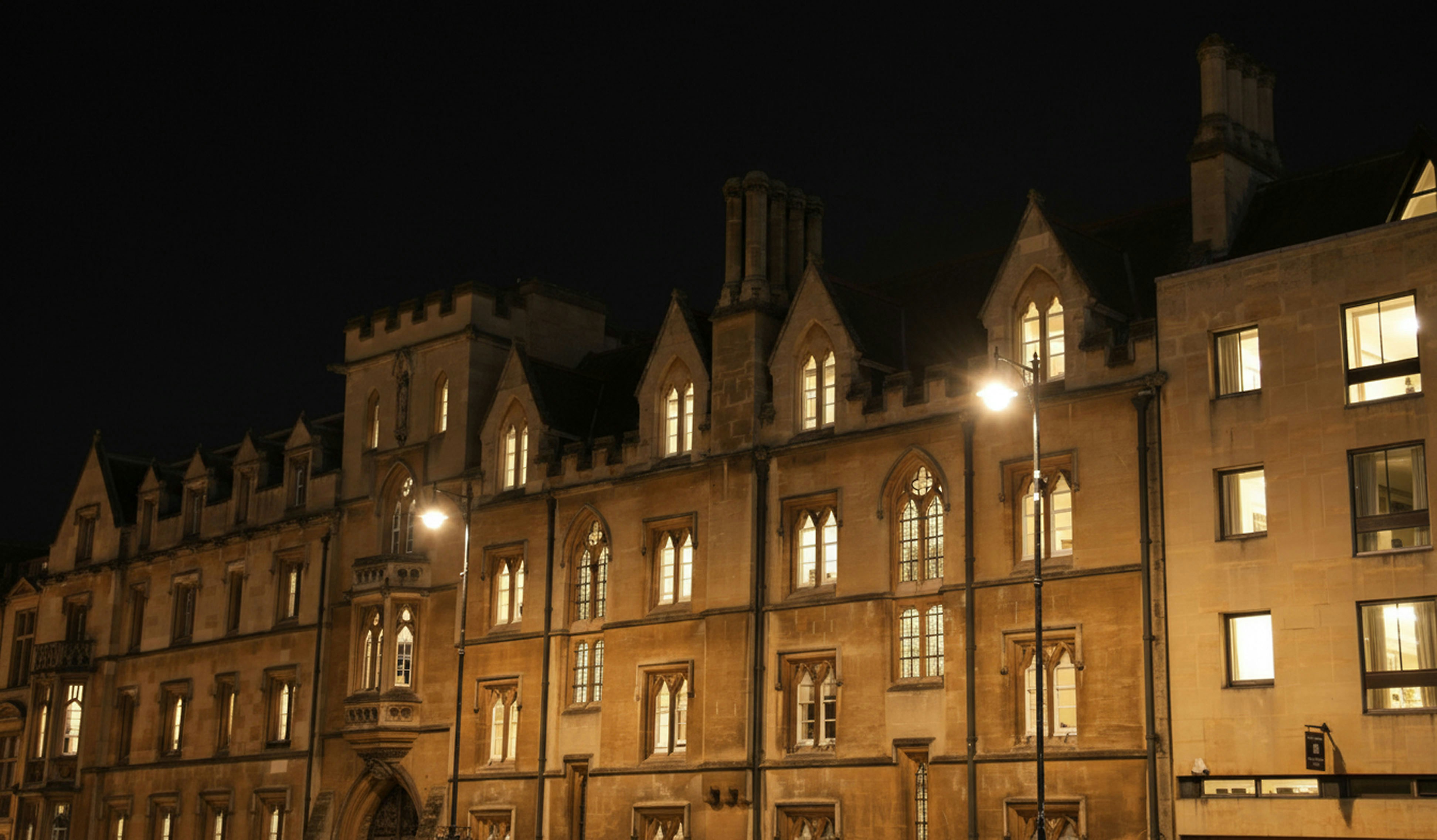 Lamplight Over Older Stone: Night Facade of a Medieval-Style Street