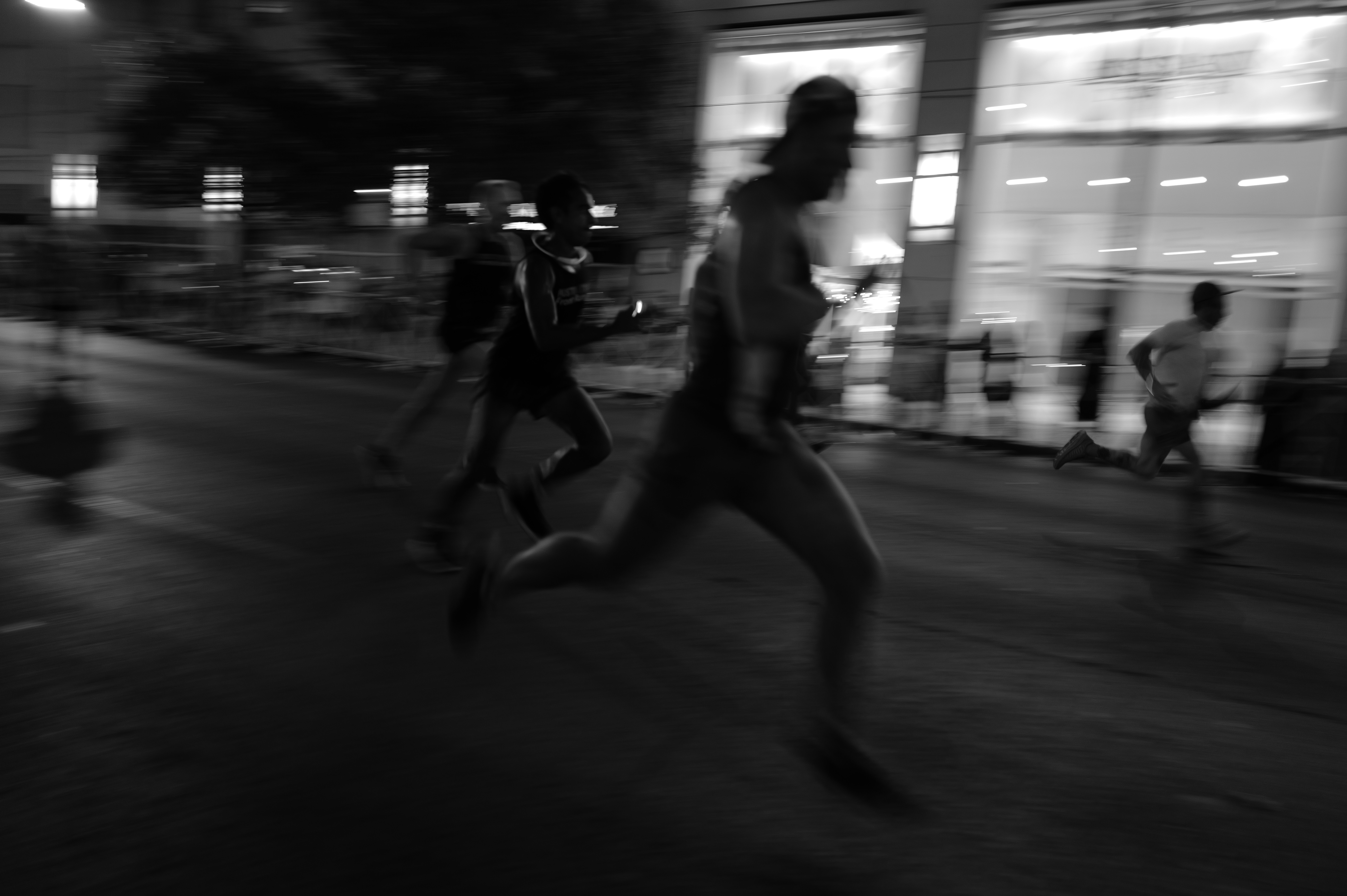 Blurring sprint: runners carve a night-time street chase