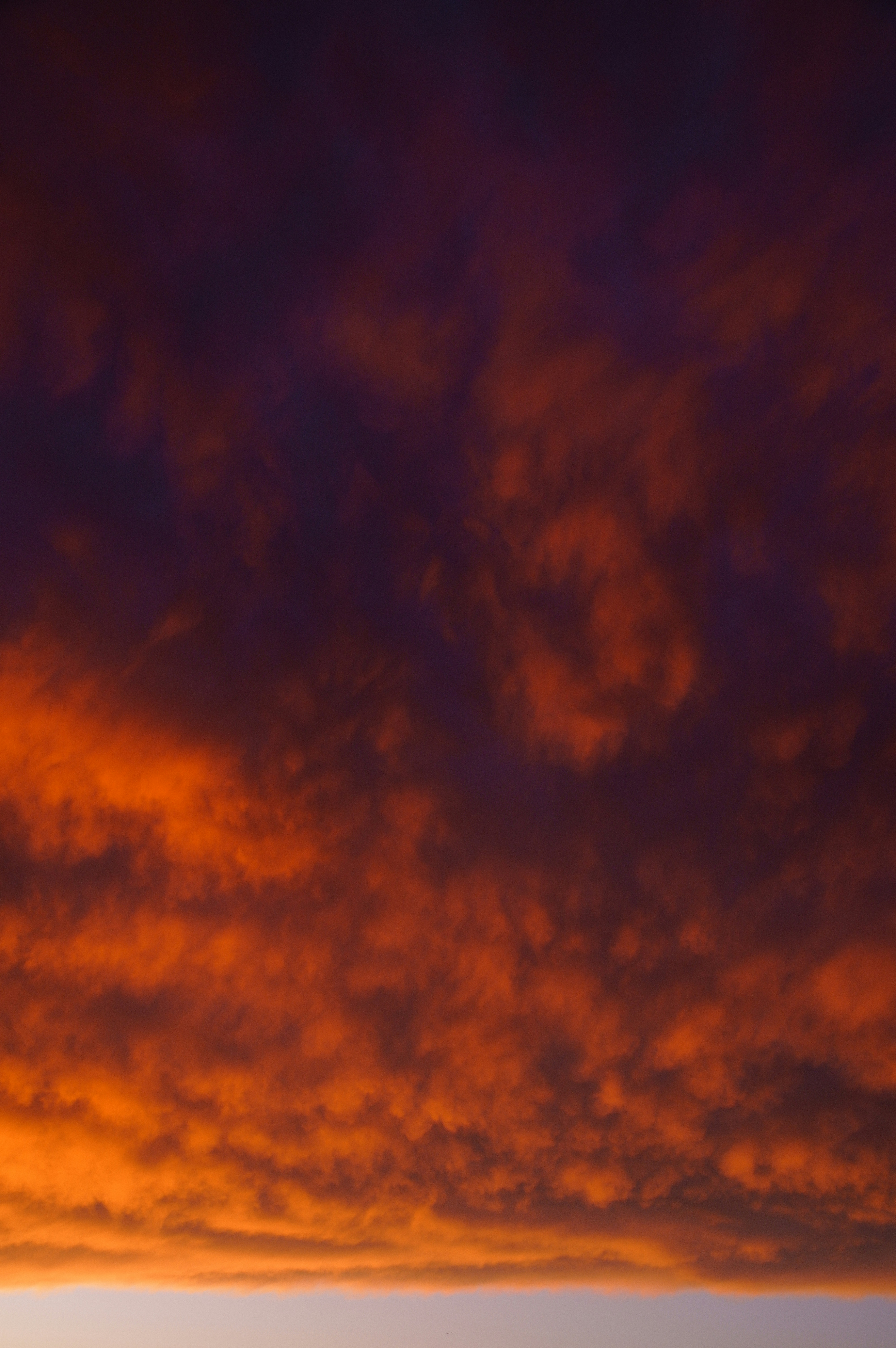 Fiery Horizon: Clouds Alight Above a Quiet Shore