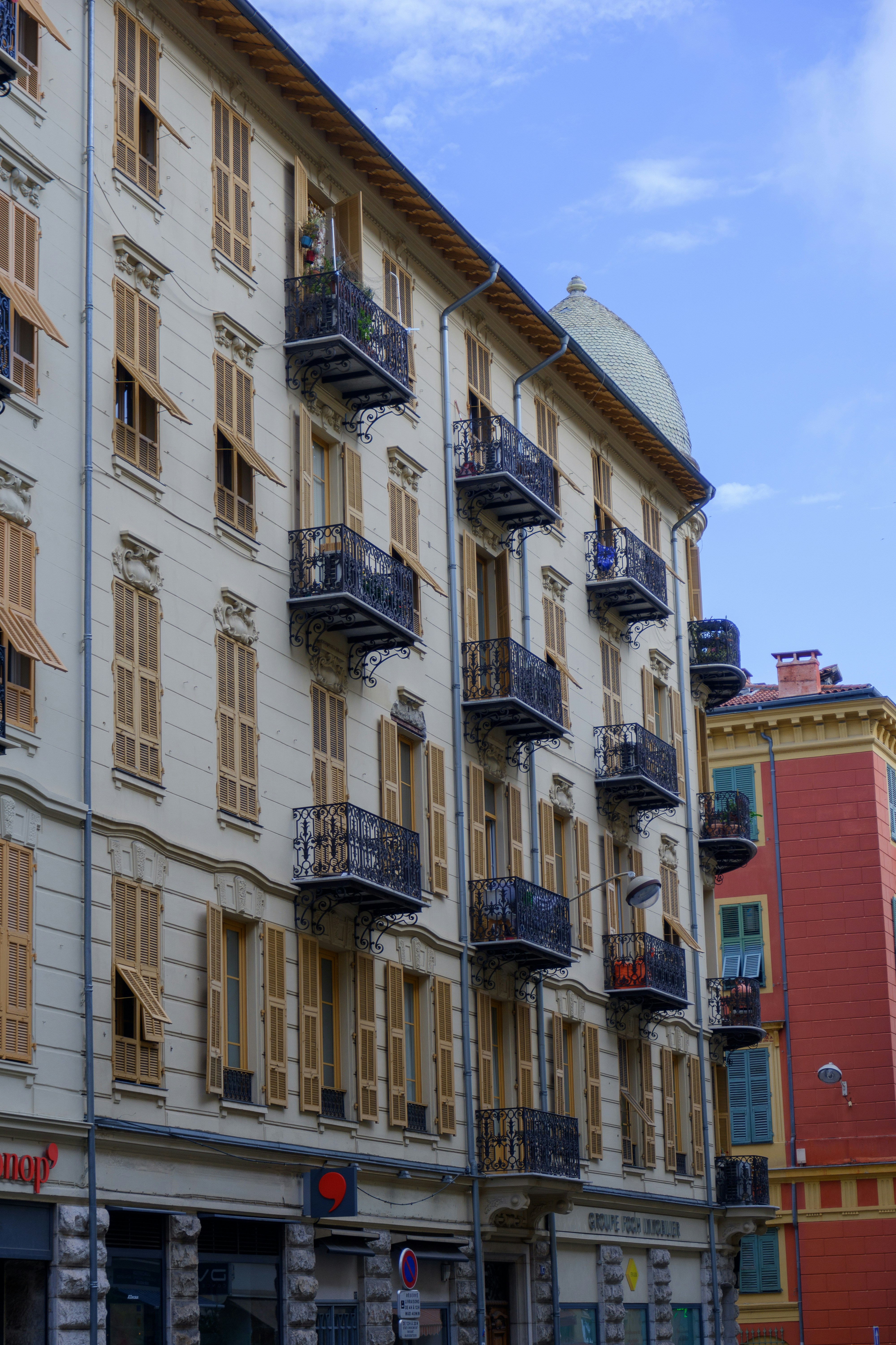 Balconies in Bloom: A European Facade Under a Clear Sky