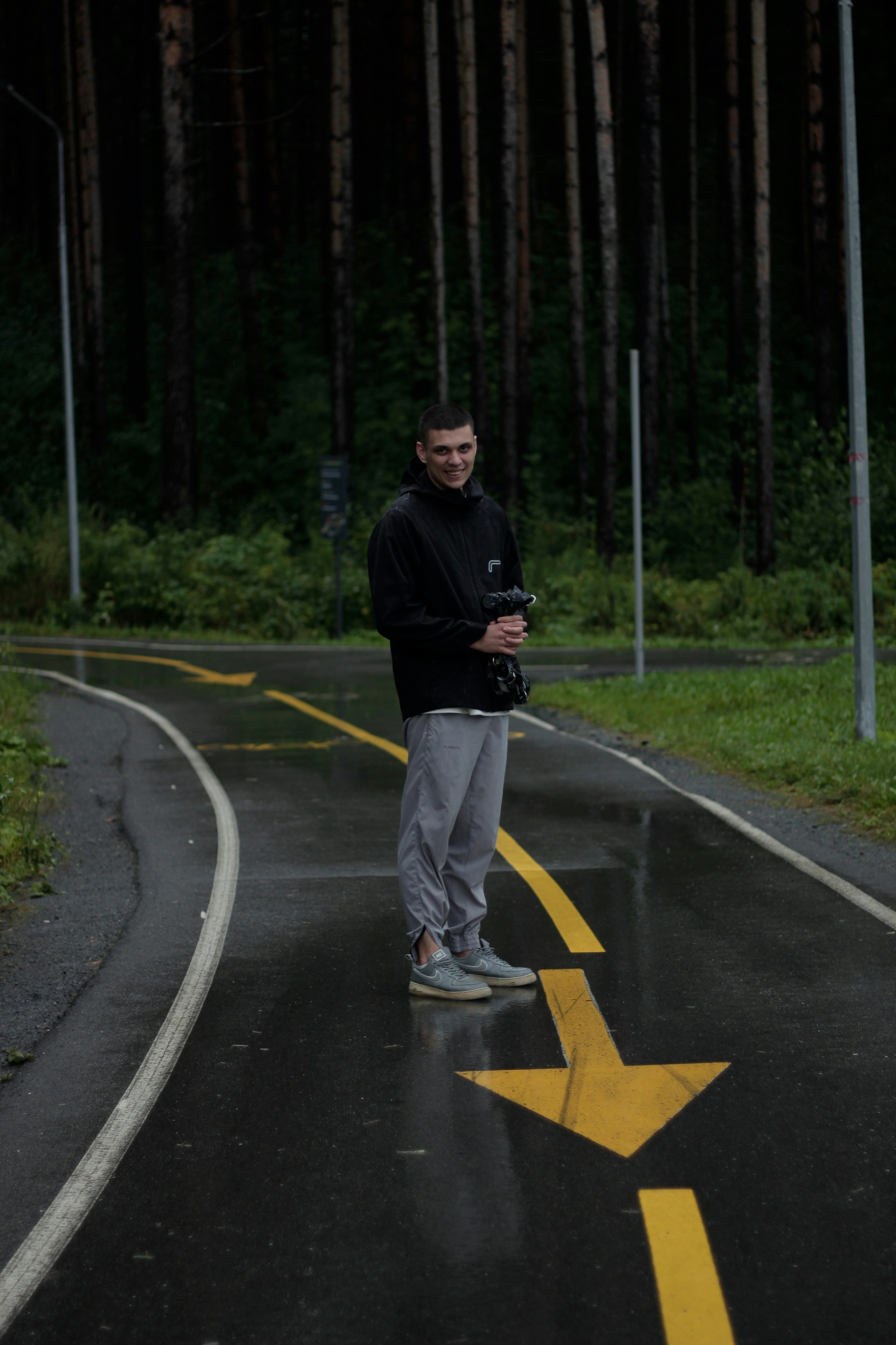 Traveler on a Rain-Slick Road Through a Quiet Forest