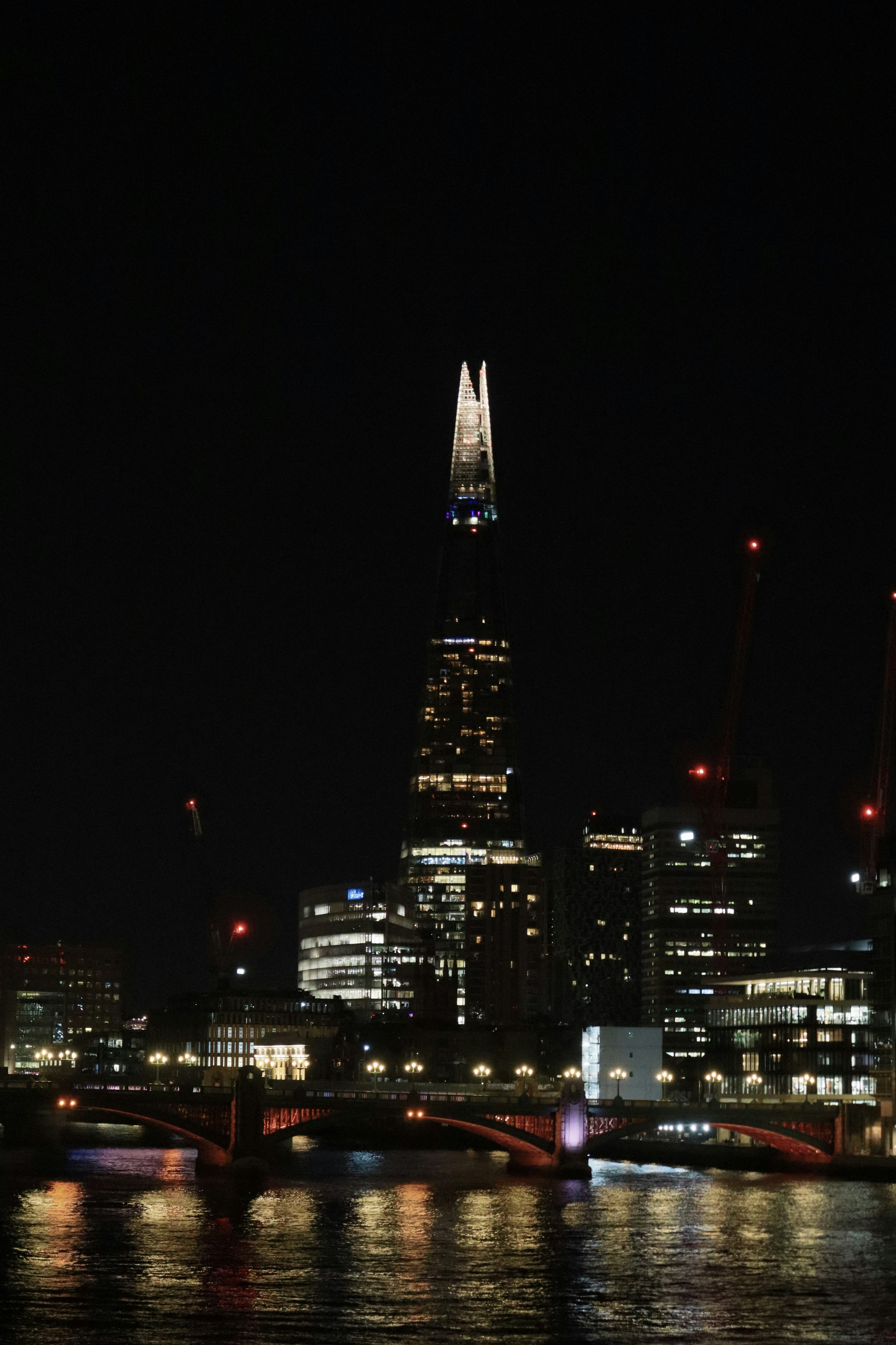 Towering Peak Over Thames: Nightscape of a Neon-lit Skyline