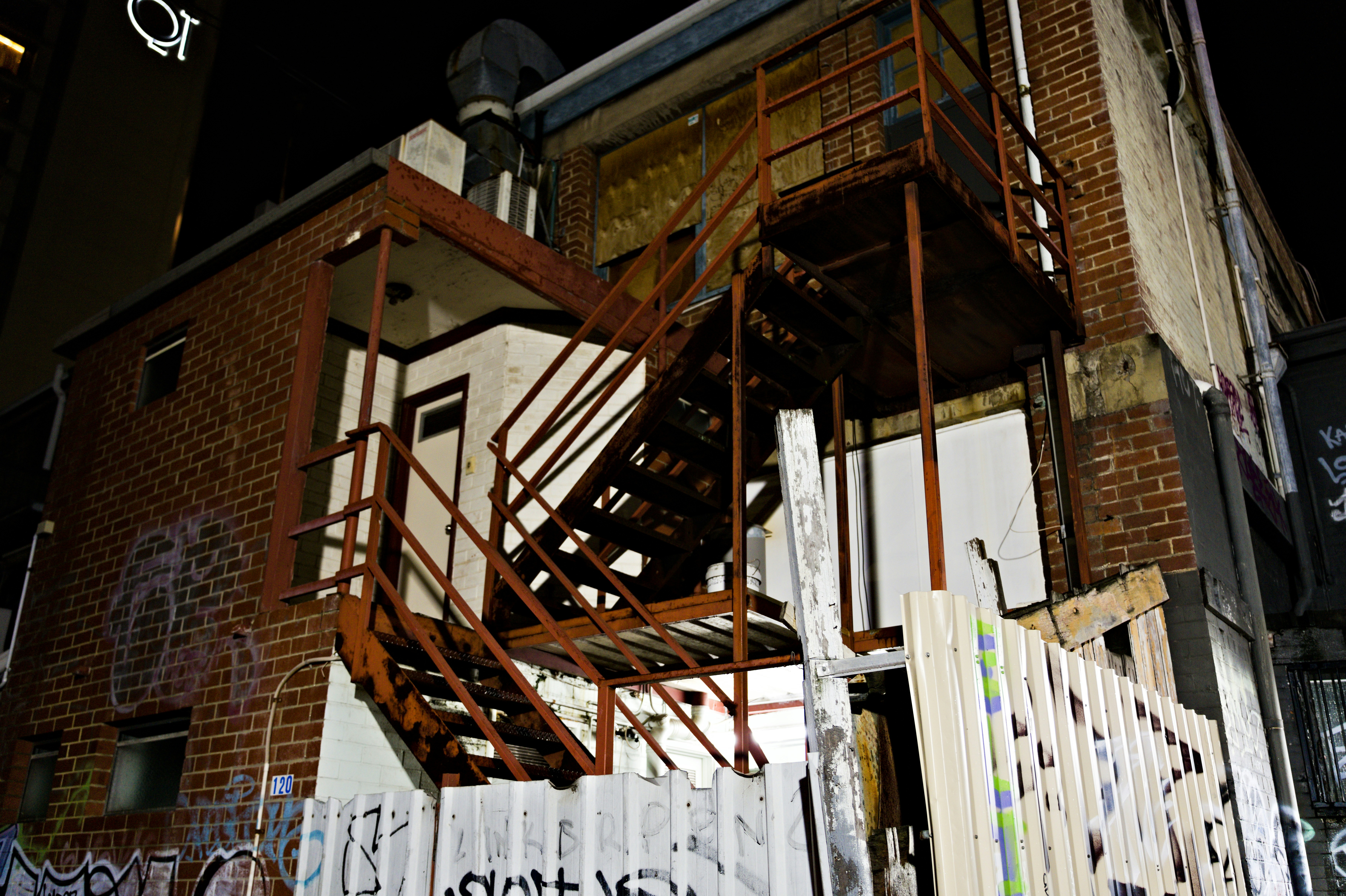 Industrial Staircase to Nowhere in Nighttime Brick Facade
