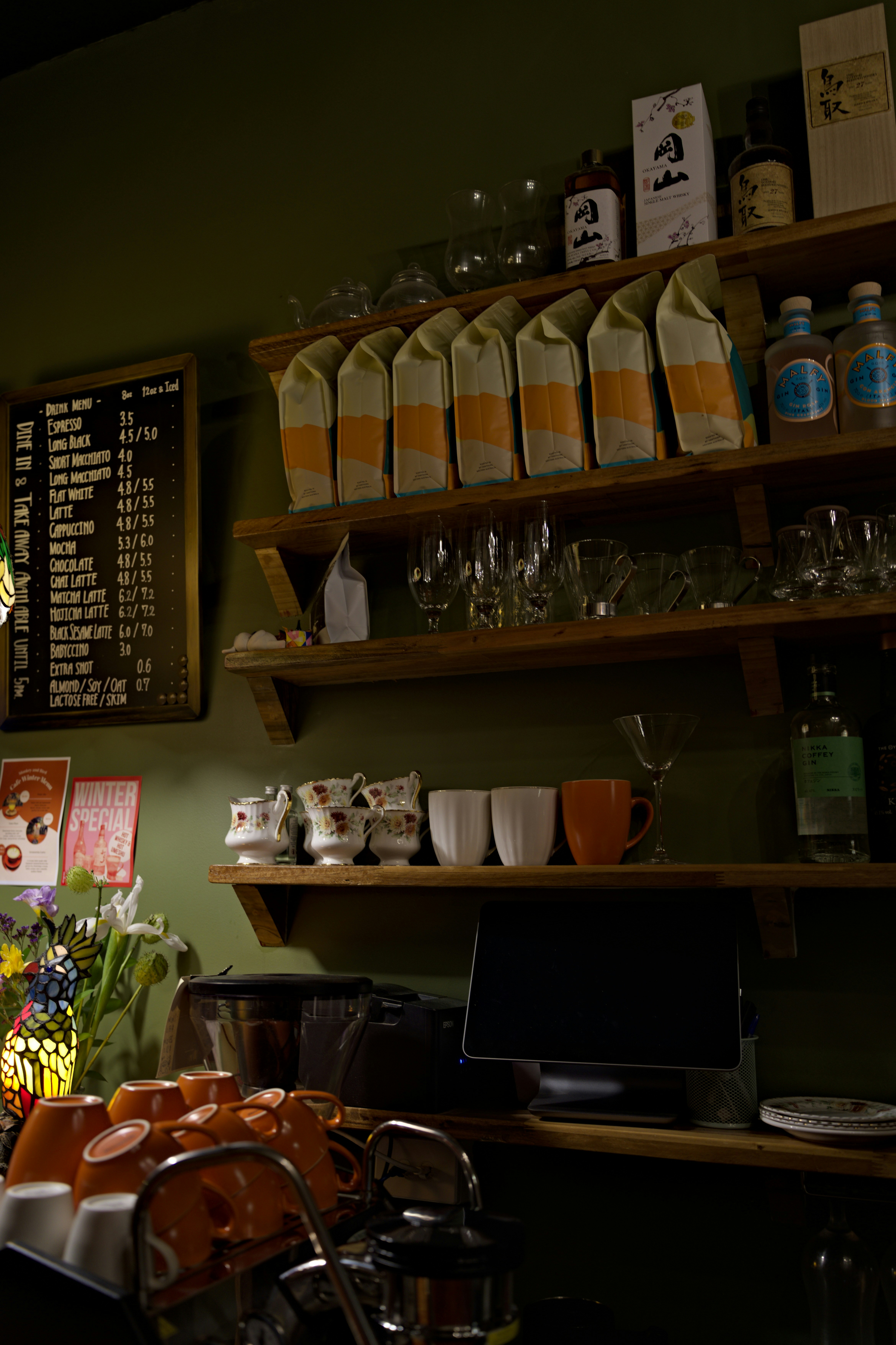 Warm Shelf of Ceramics and Tea in a Quiet Café