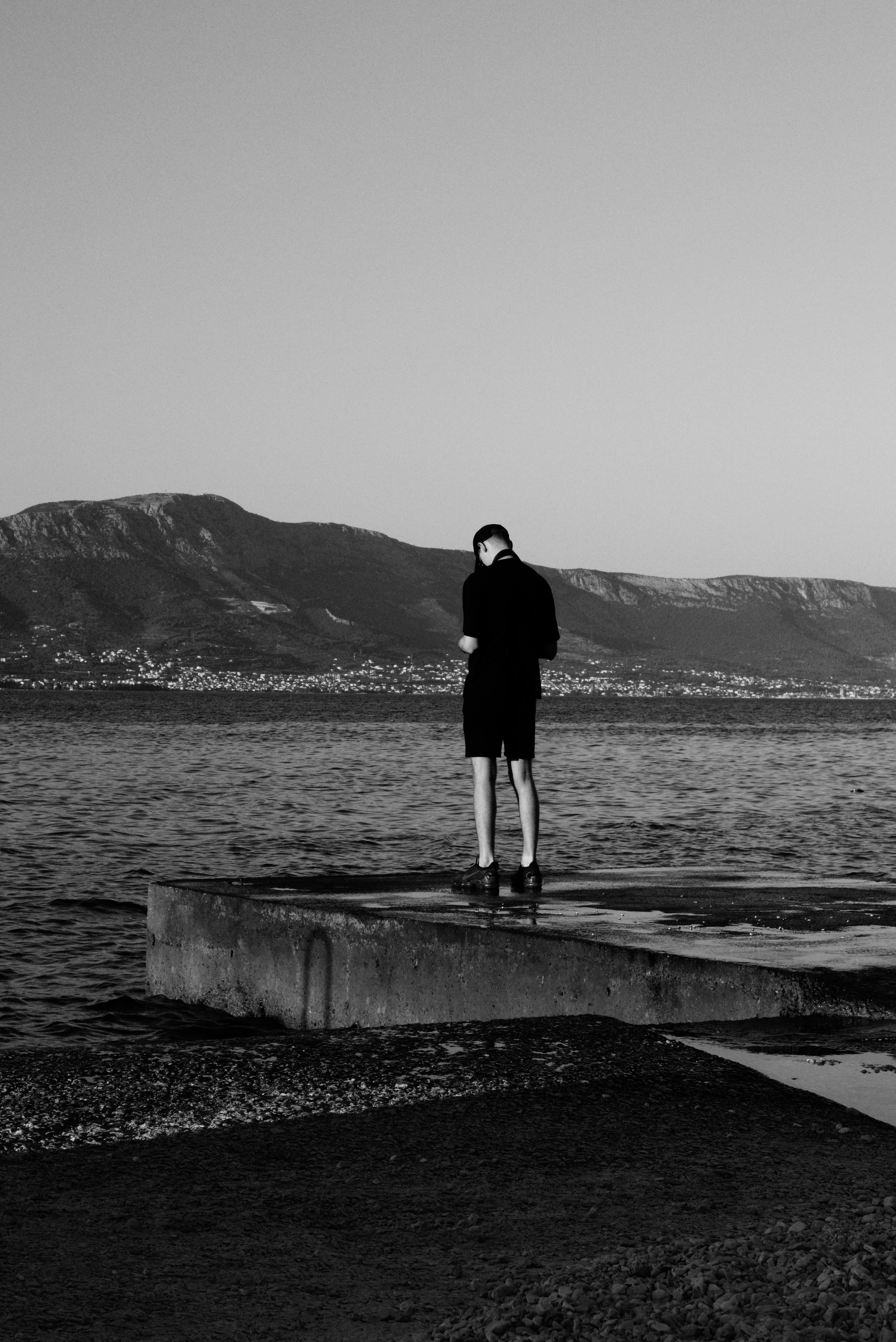 Lonely Figure at the Pier: A Quiet Monochrome Moment