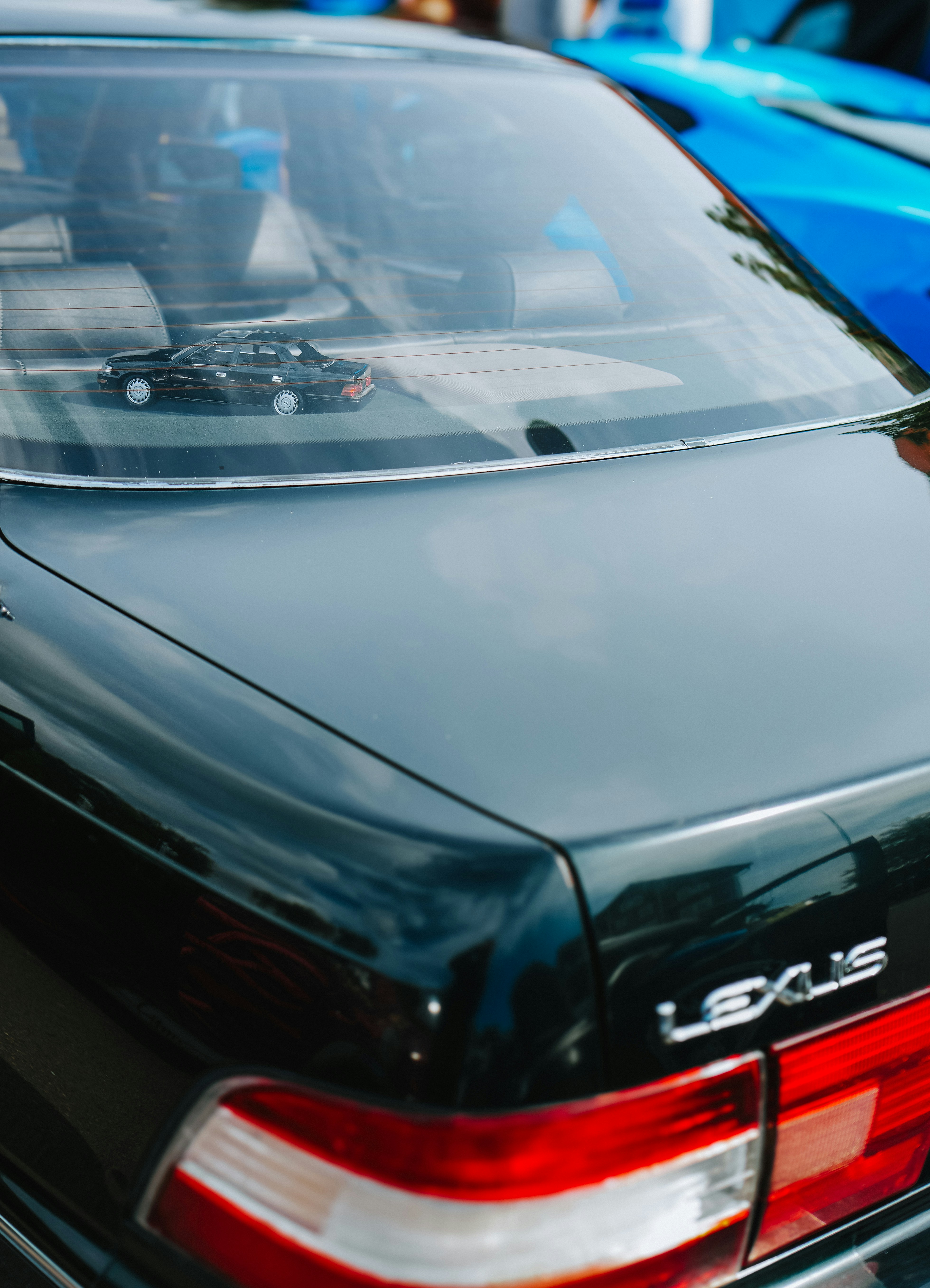 Miniature Car on a Real Car: A Toy-Tale Resting on the Windshield