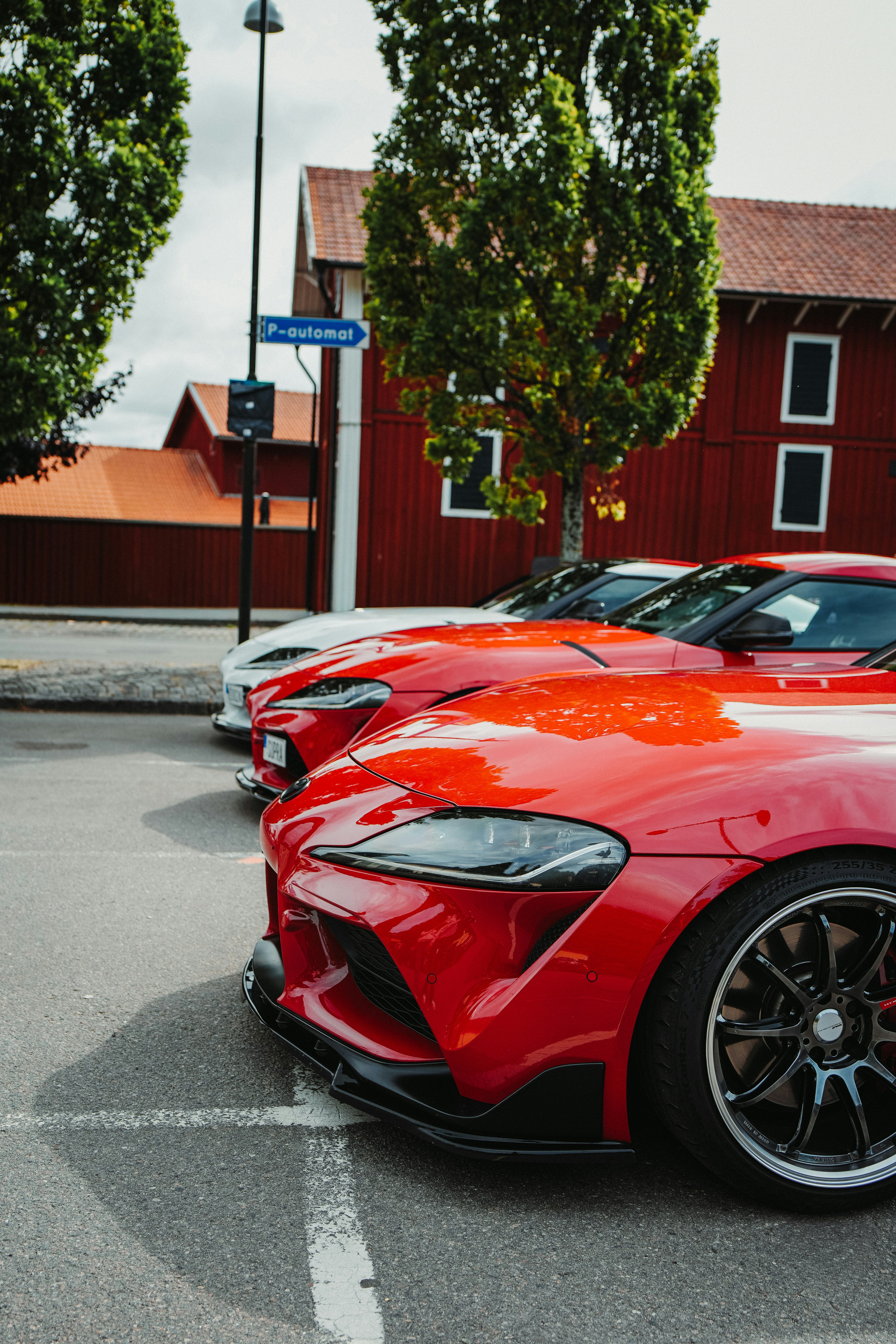 Red Veloce: A Row of Storm-Color Cars in a Nordic Parking Lot